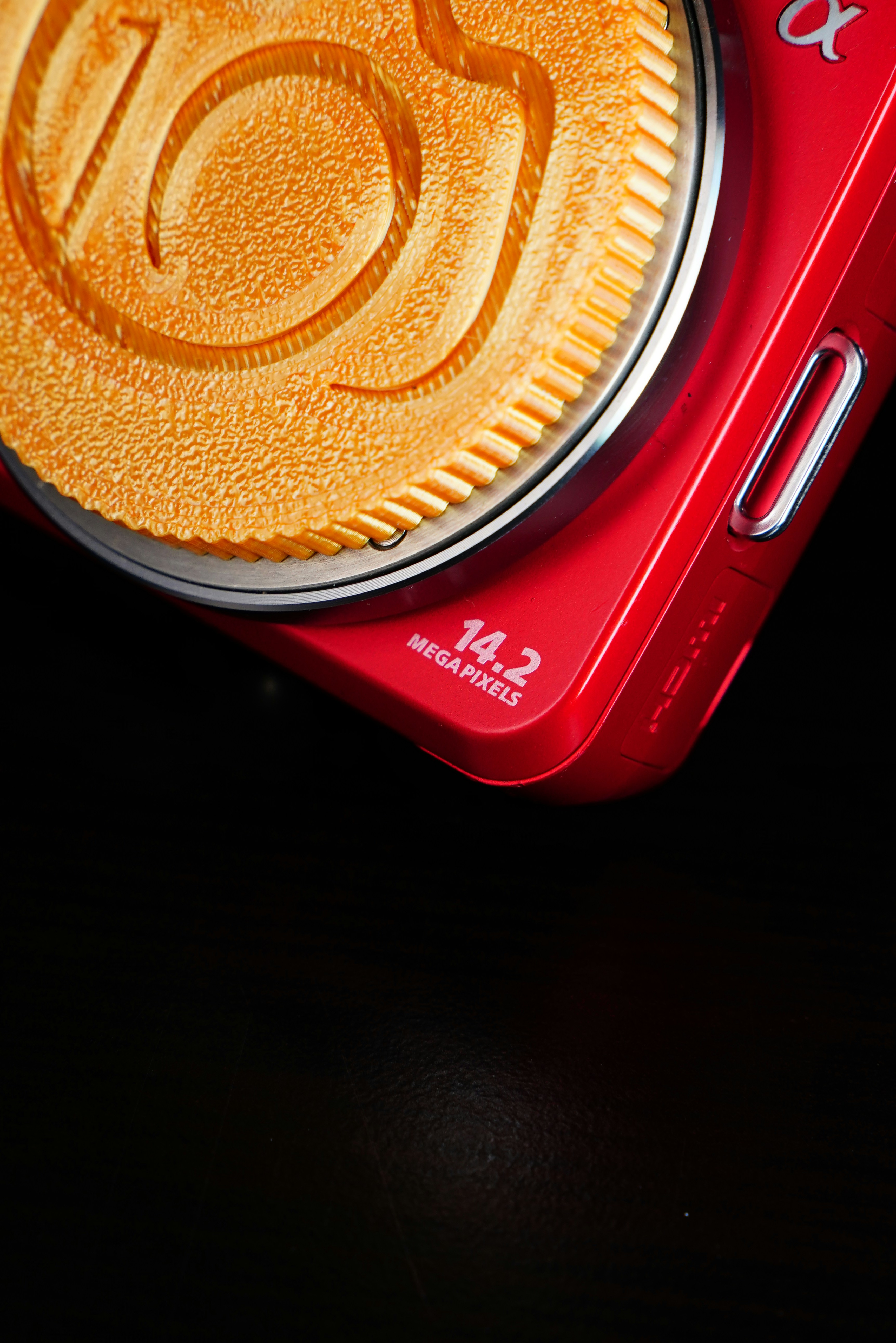 Crimson close-up: a Sony RX-style camera lens cap in macro detail
