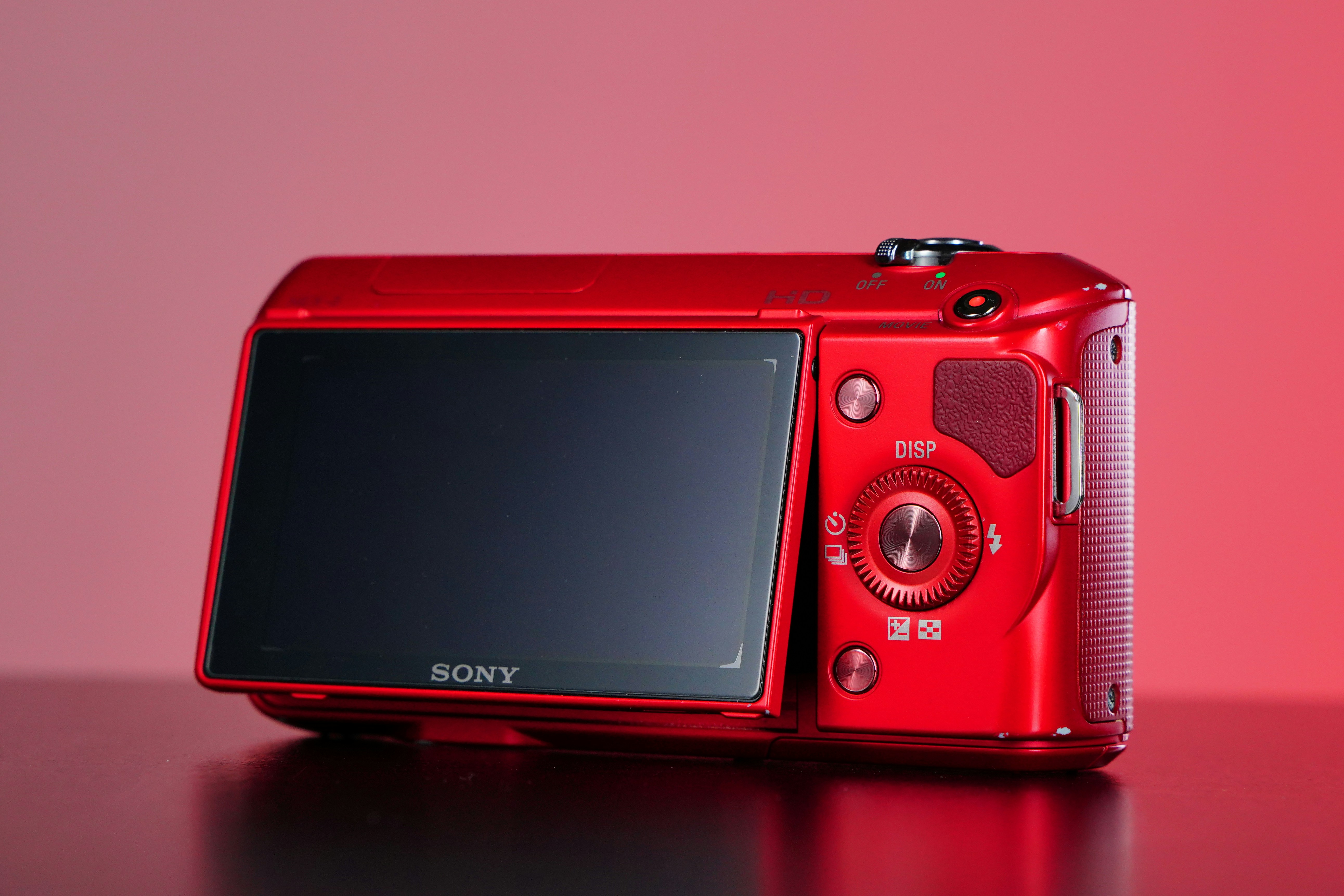 A red digital camera sitting on top of a table photo – Free Gadget ...