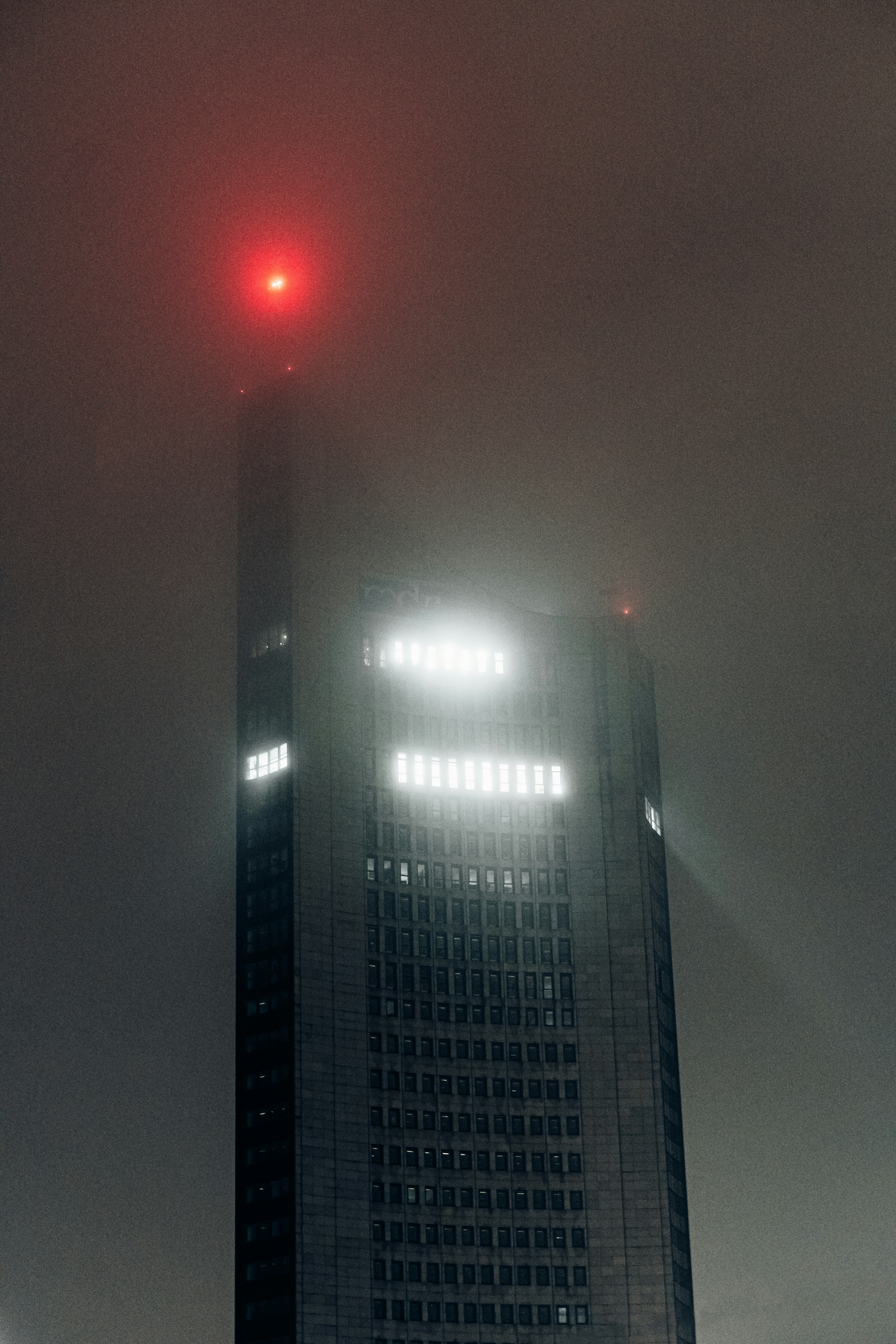 A tall building with a red light on top of it photo – Free Uniriese ...