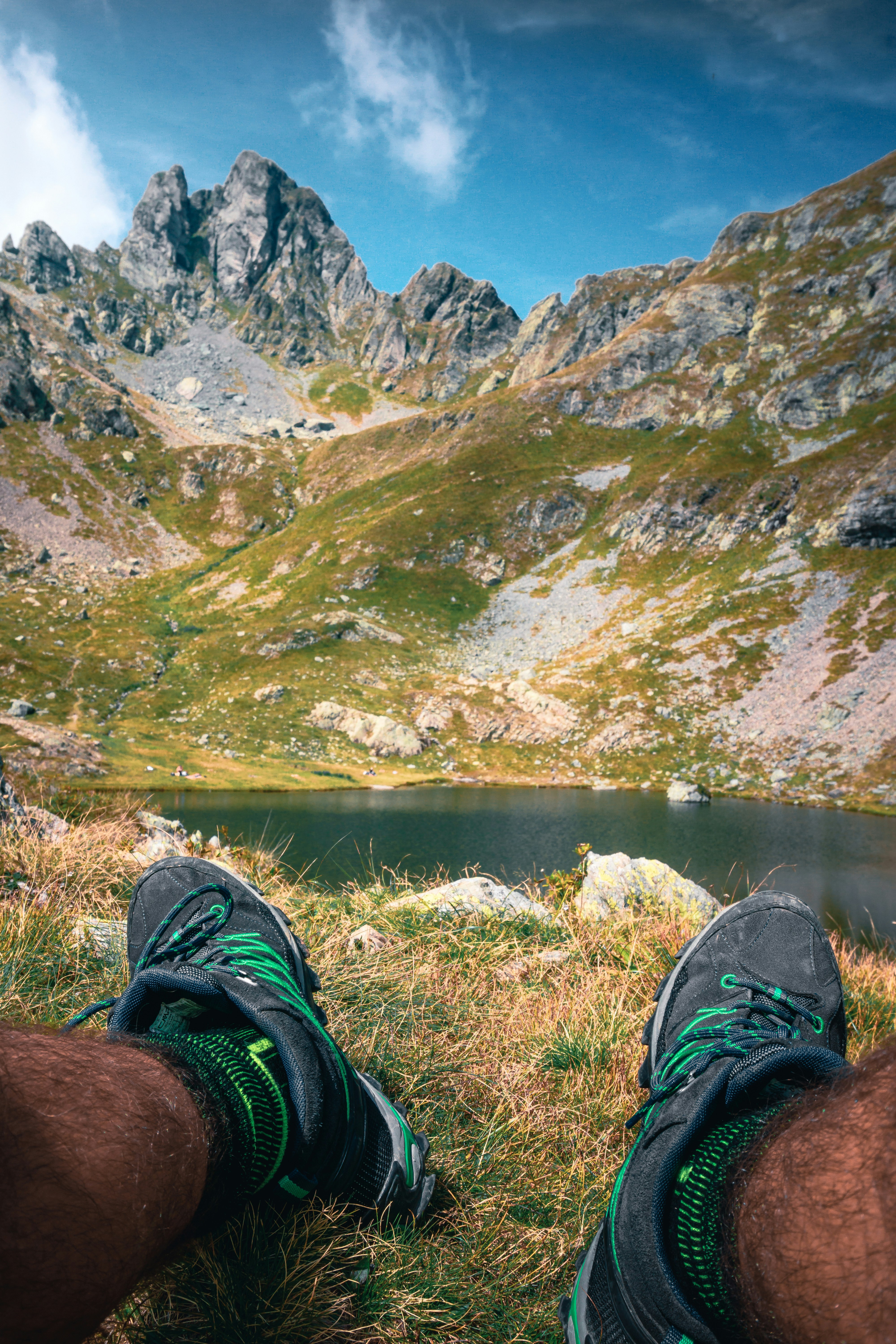 Edge of the Alpine Quiet: Boots Framing a Mirrored Lake Beneath Jagged Peaks