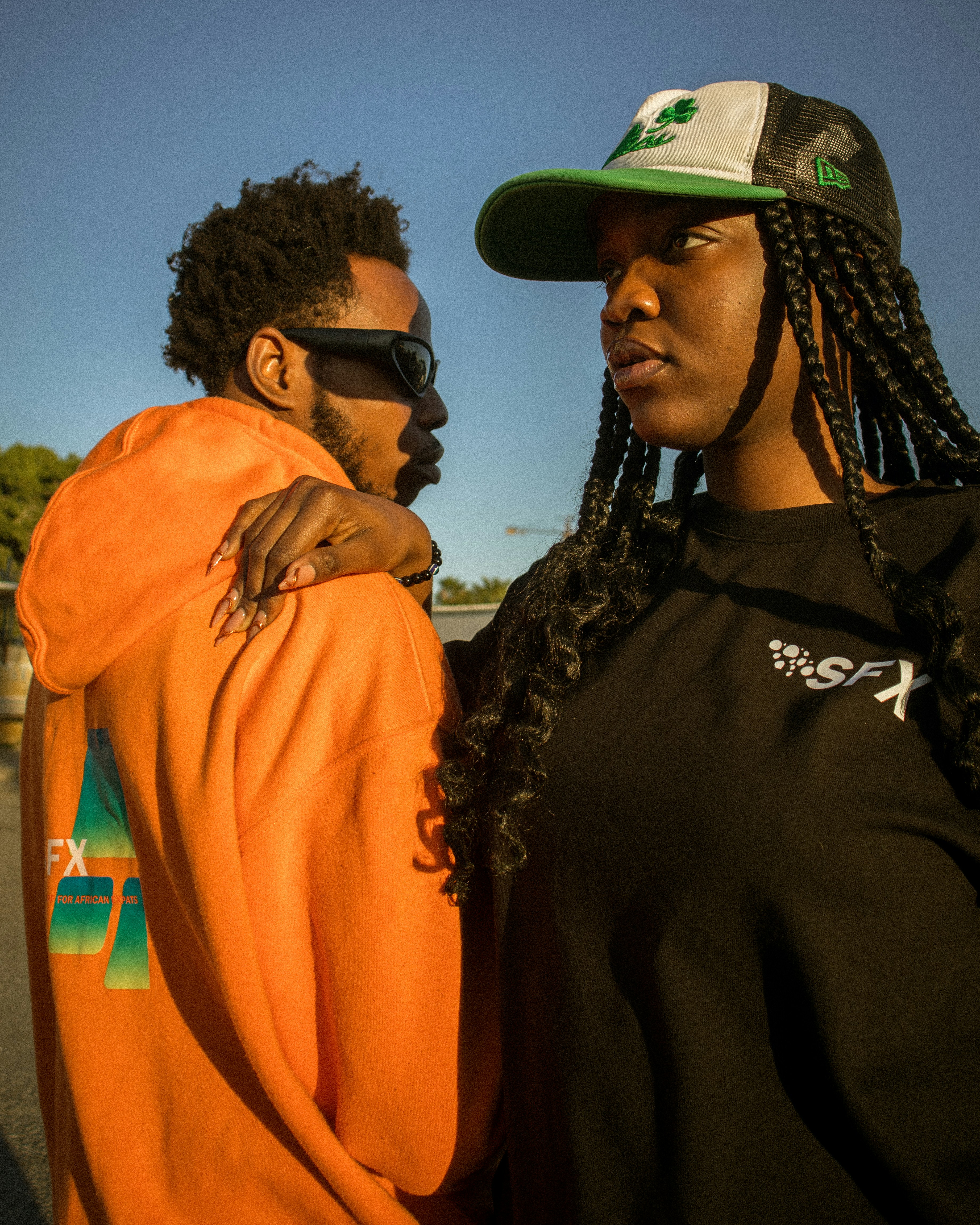 Two friends in warm sun, close-up portrait with contrasting outfits