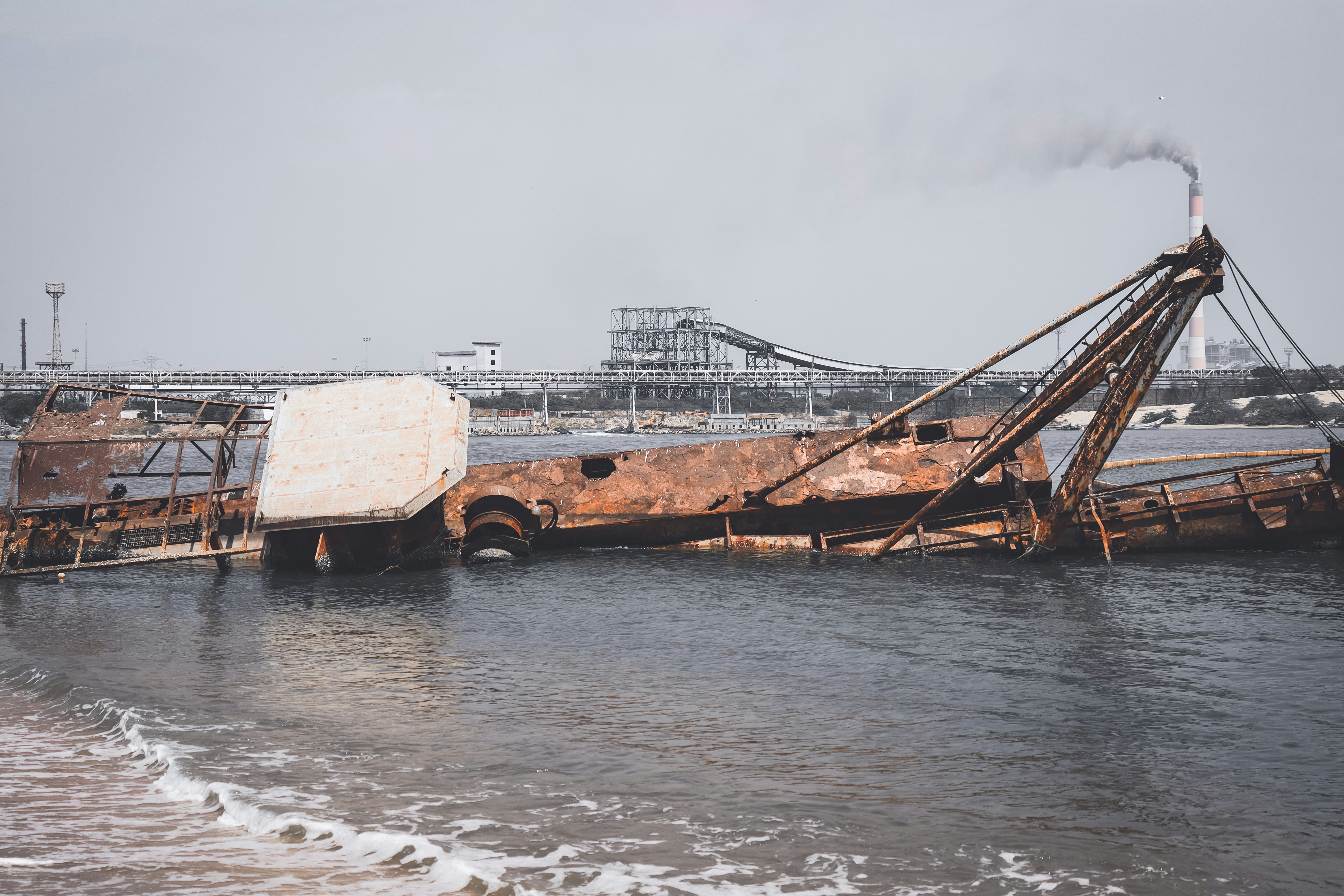 A rusted boat sitting on top of a body of water photo – Free Boat Image ...