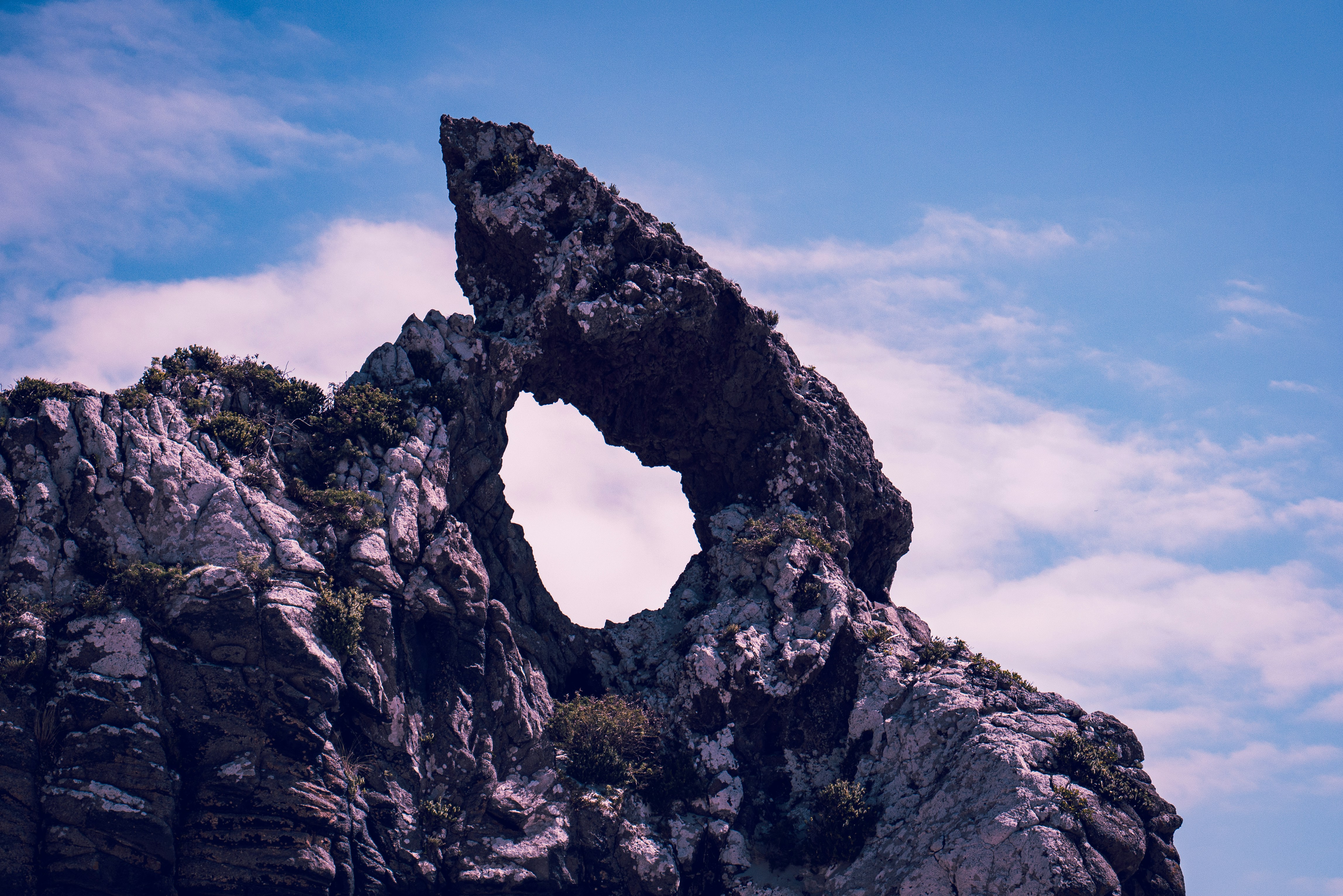 A rock formation with a hole in the middle of it photo – Free Wallpaper ...