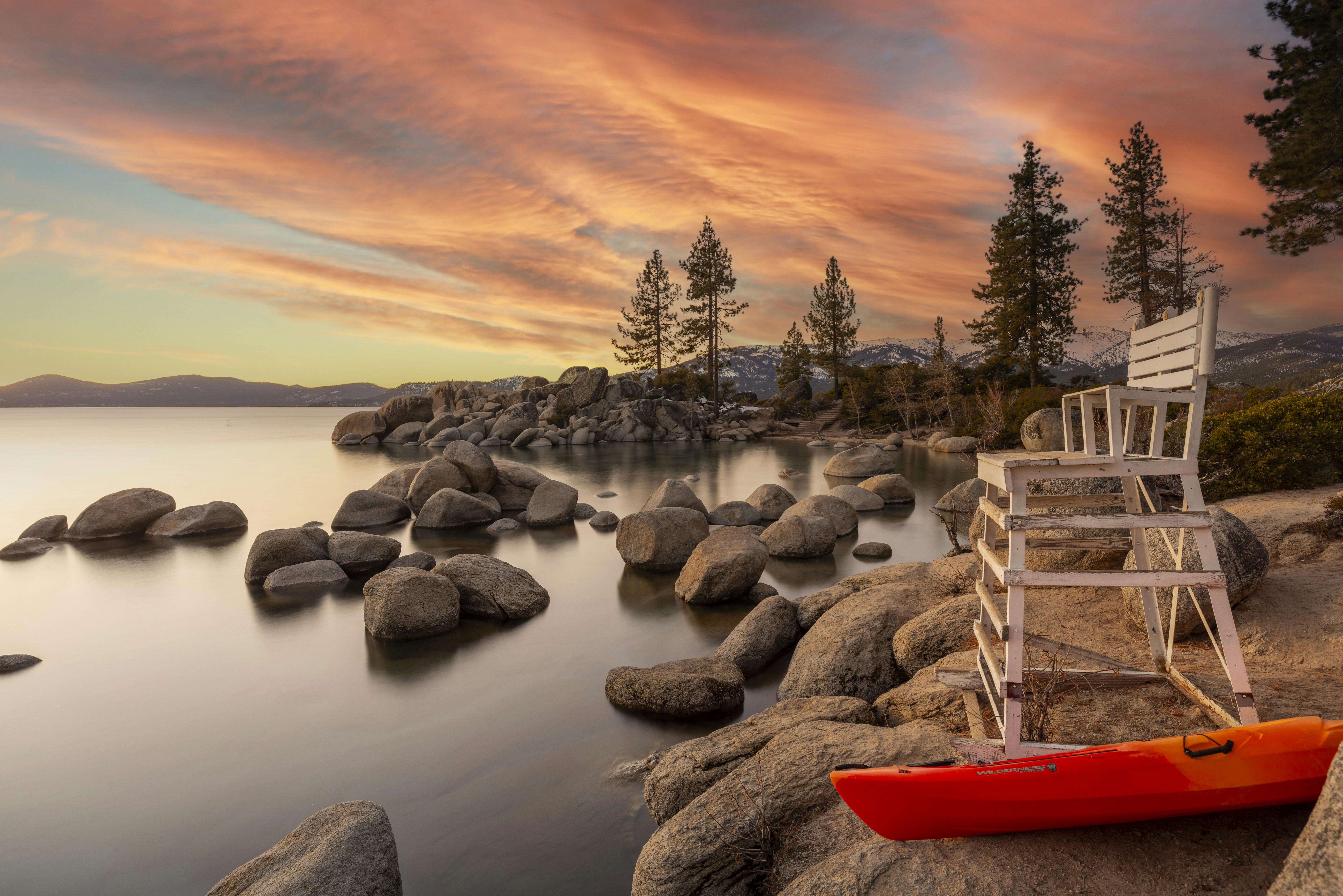 A red kayak sitting on the shore of a lake photo – Free Scenery Image ...