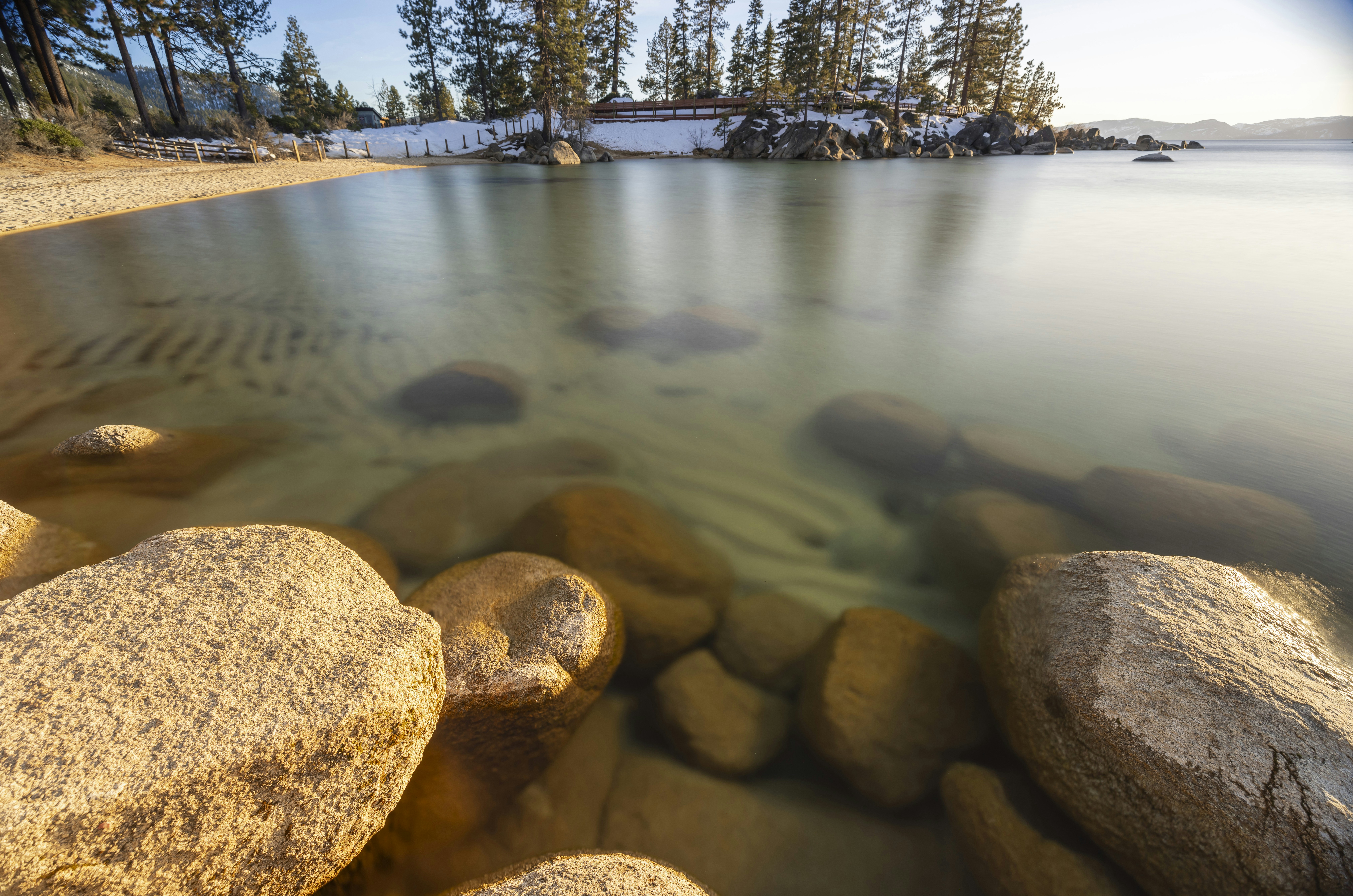 A body of water surrounded by rocks and trees photo – Free Rock Image ...