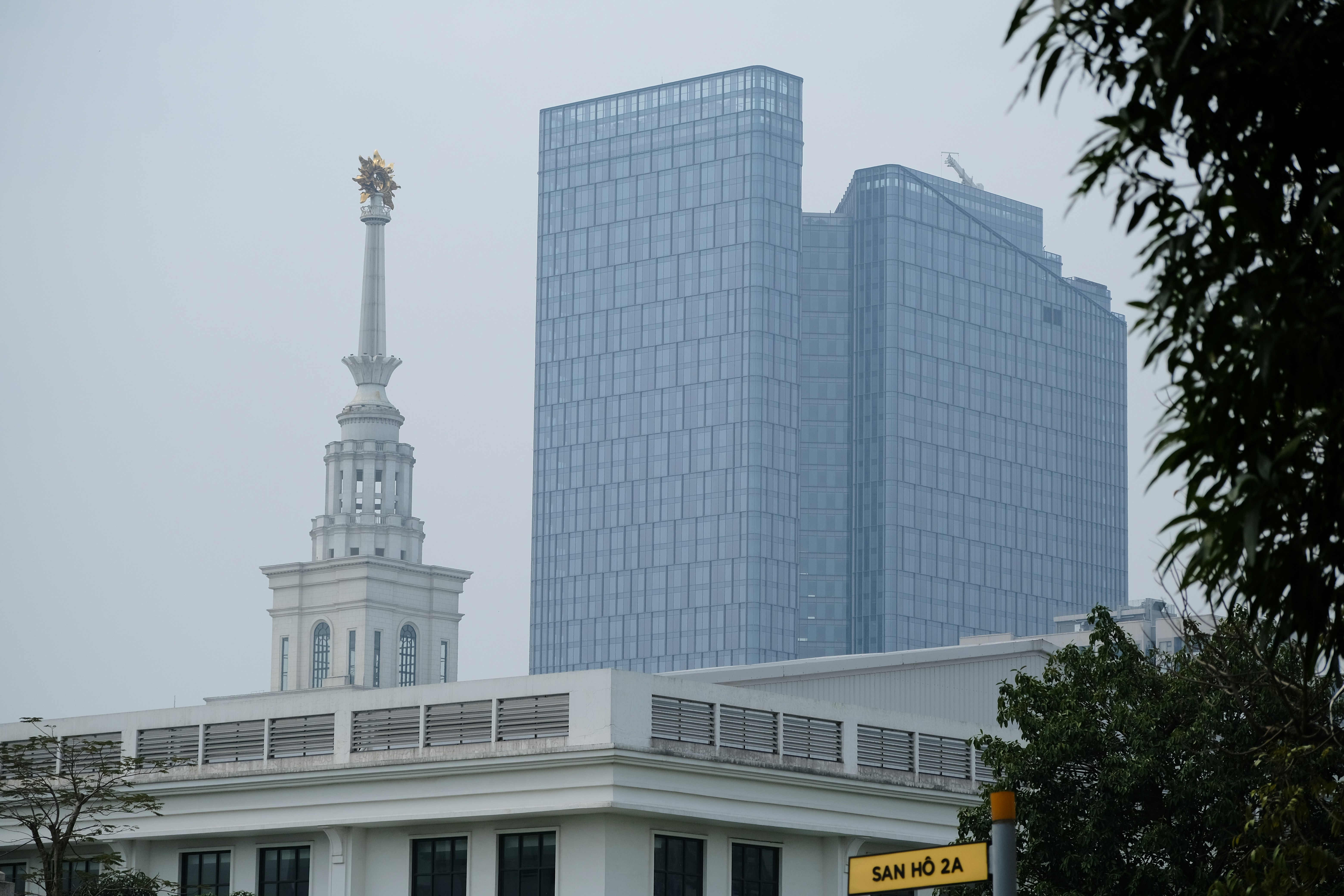City Tower and Modern Glass Block Rise Over Classic Flat-Roofed Building