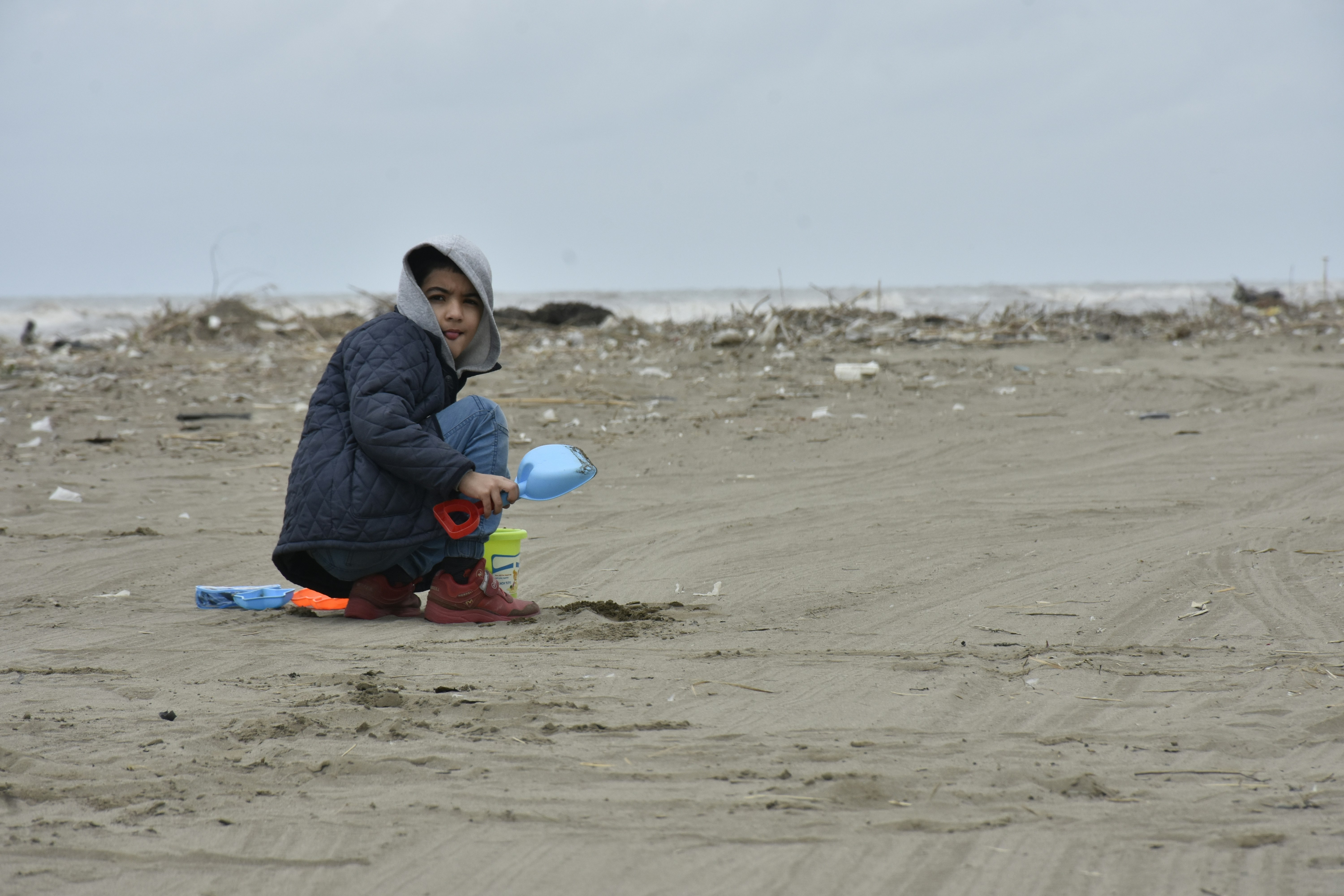 Child with a blue balloon on a desolate beach