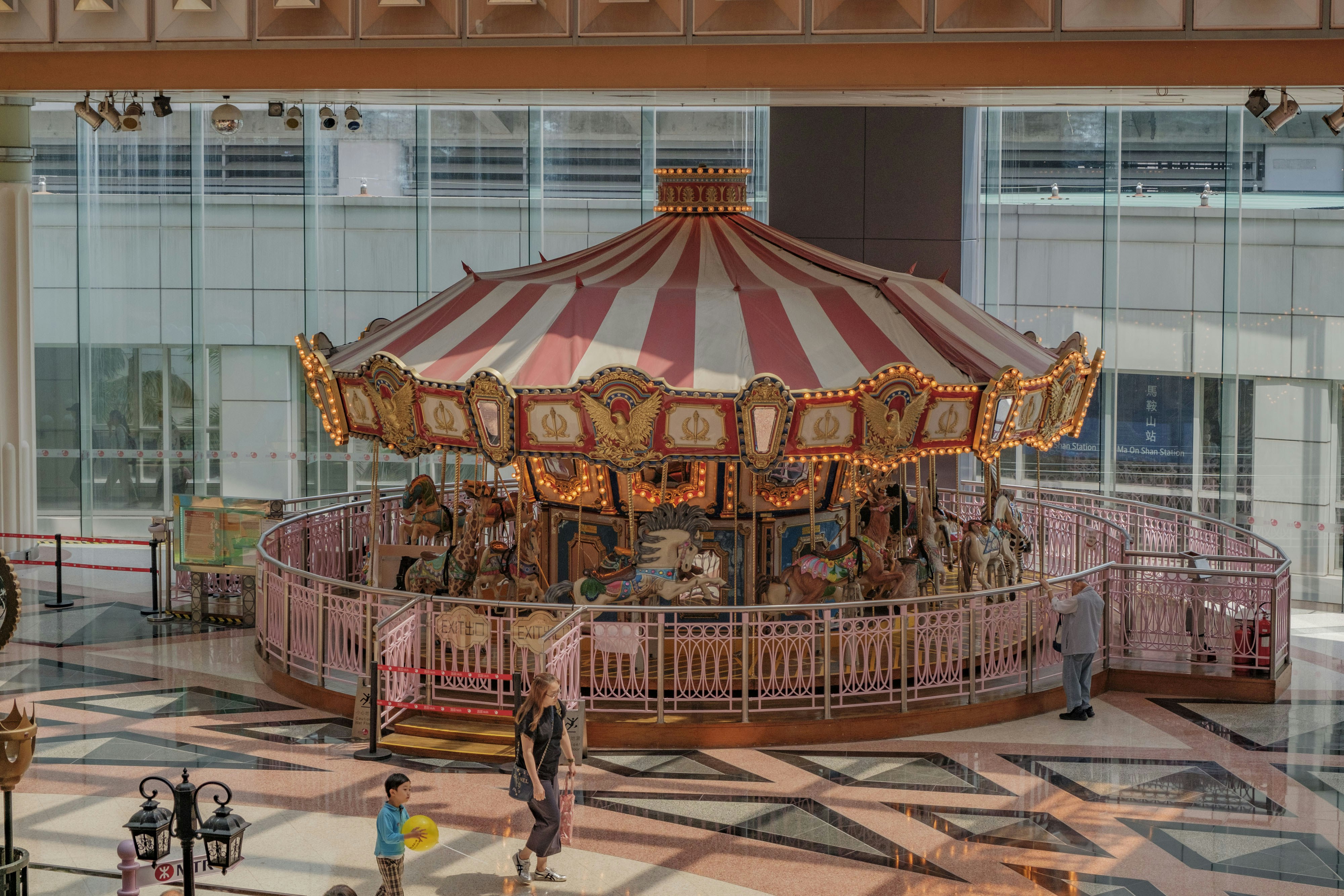 A carousel inside of a building with people walking around photo – Free ...