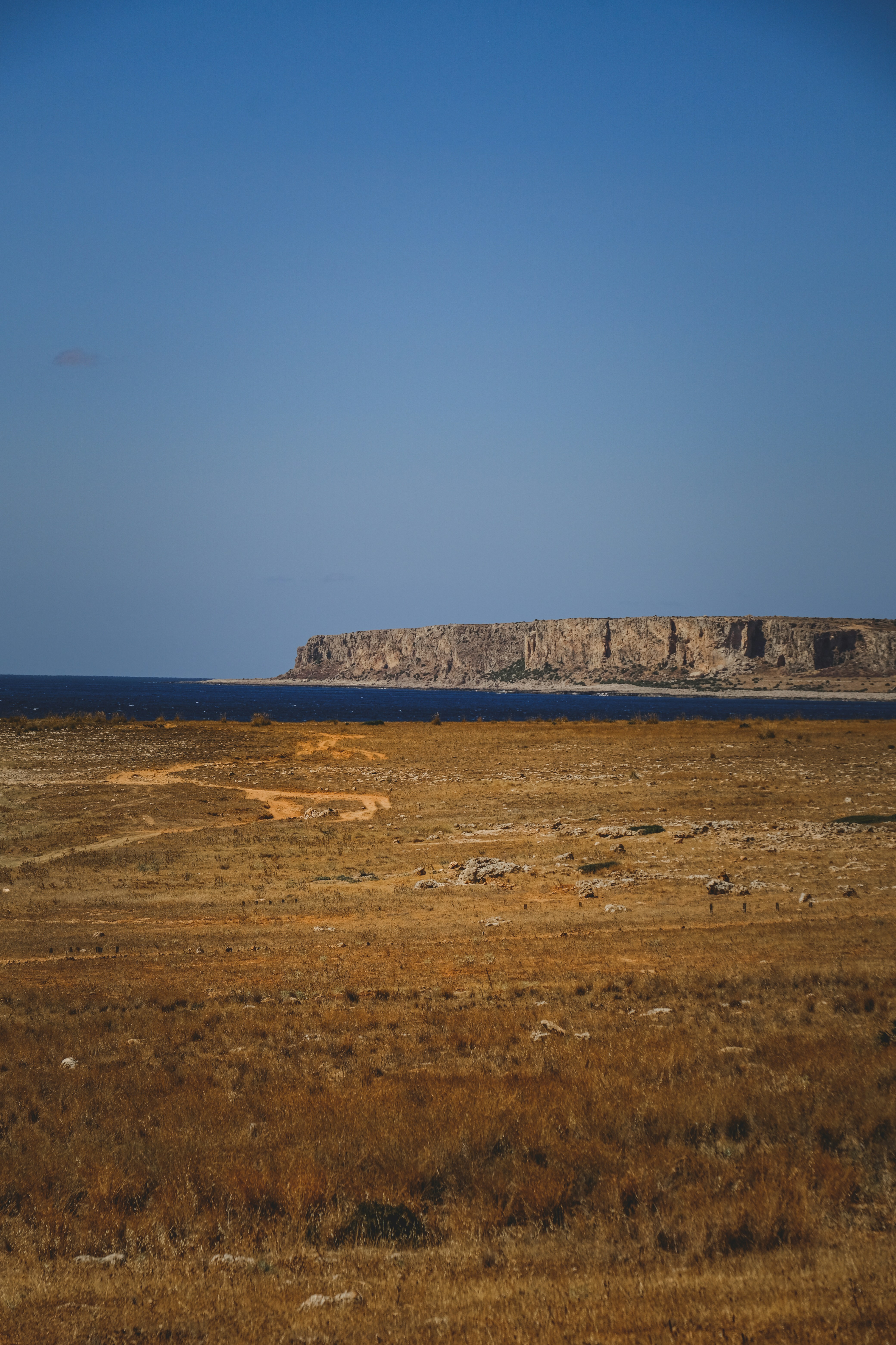 A large open field with a rock outcropping in the distance photo – Free ...