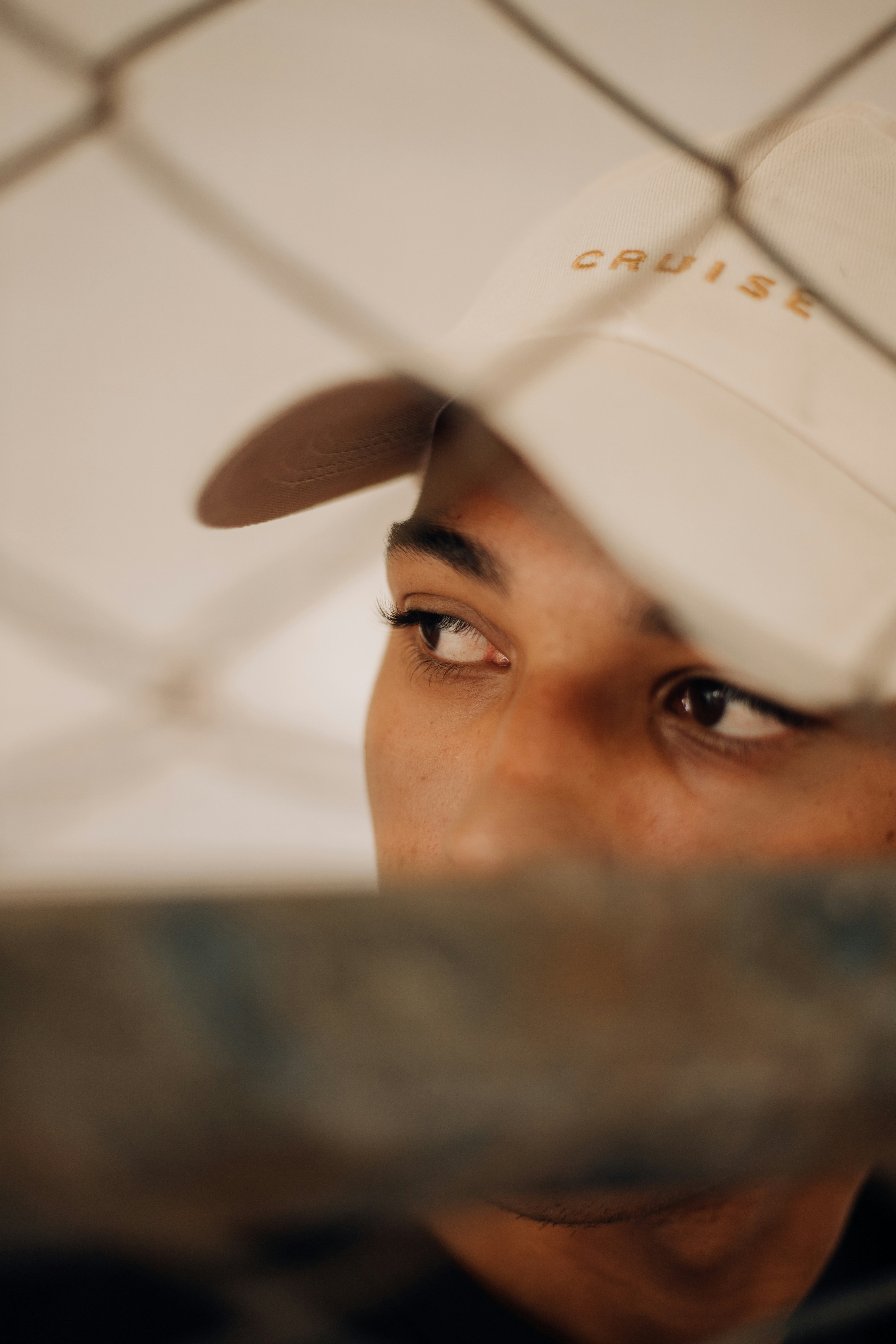 Eyes Behind the Mesh: A Portrait Through the Fence