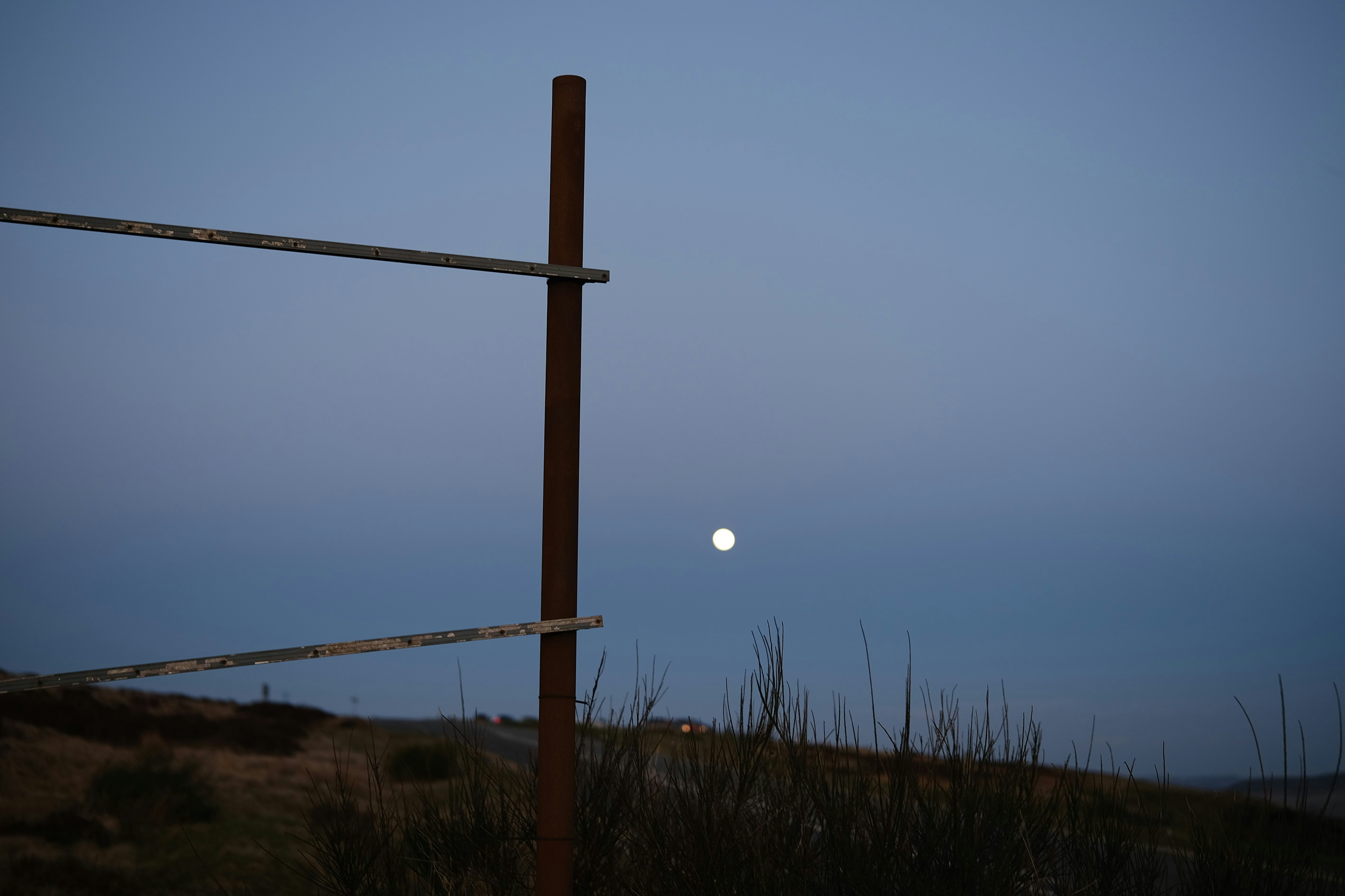 Moonrise Over a Weathered Fence in Quiet Dusk