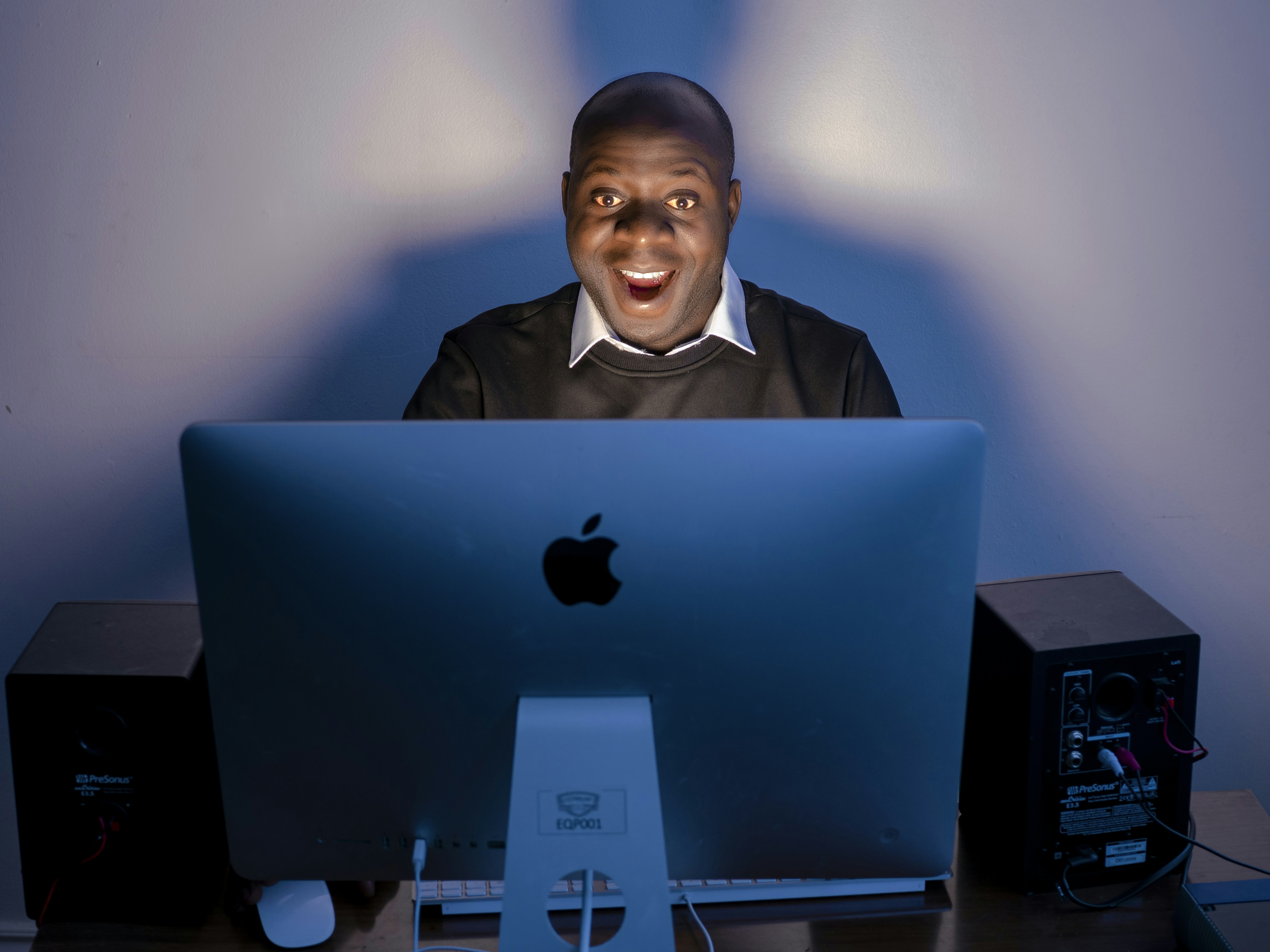 A man sitting in front of a computer on a desk photo – Free Happy man ...