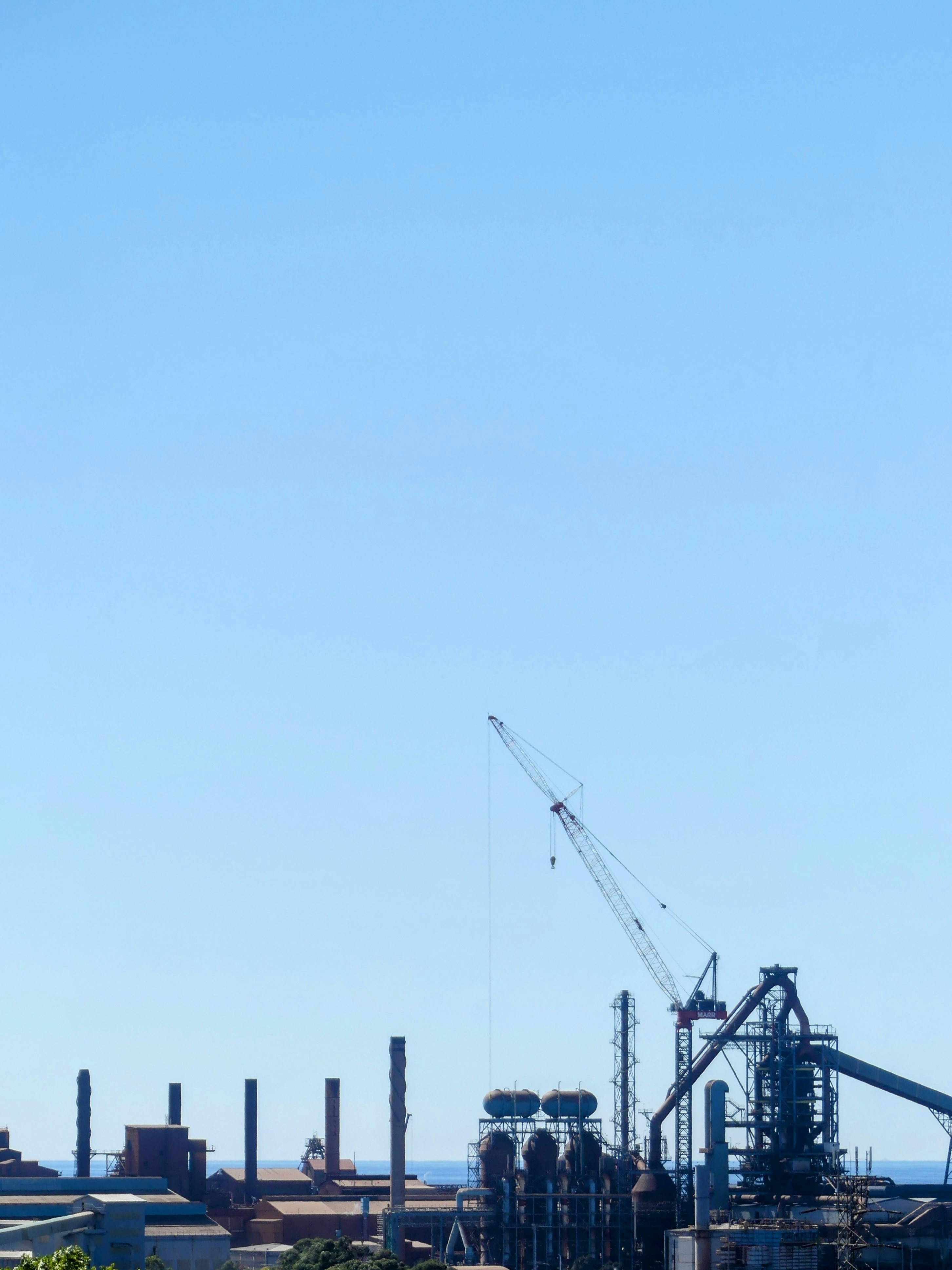 Crane Silhouette Over a Quiet Industrial Horizon