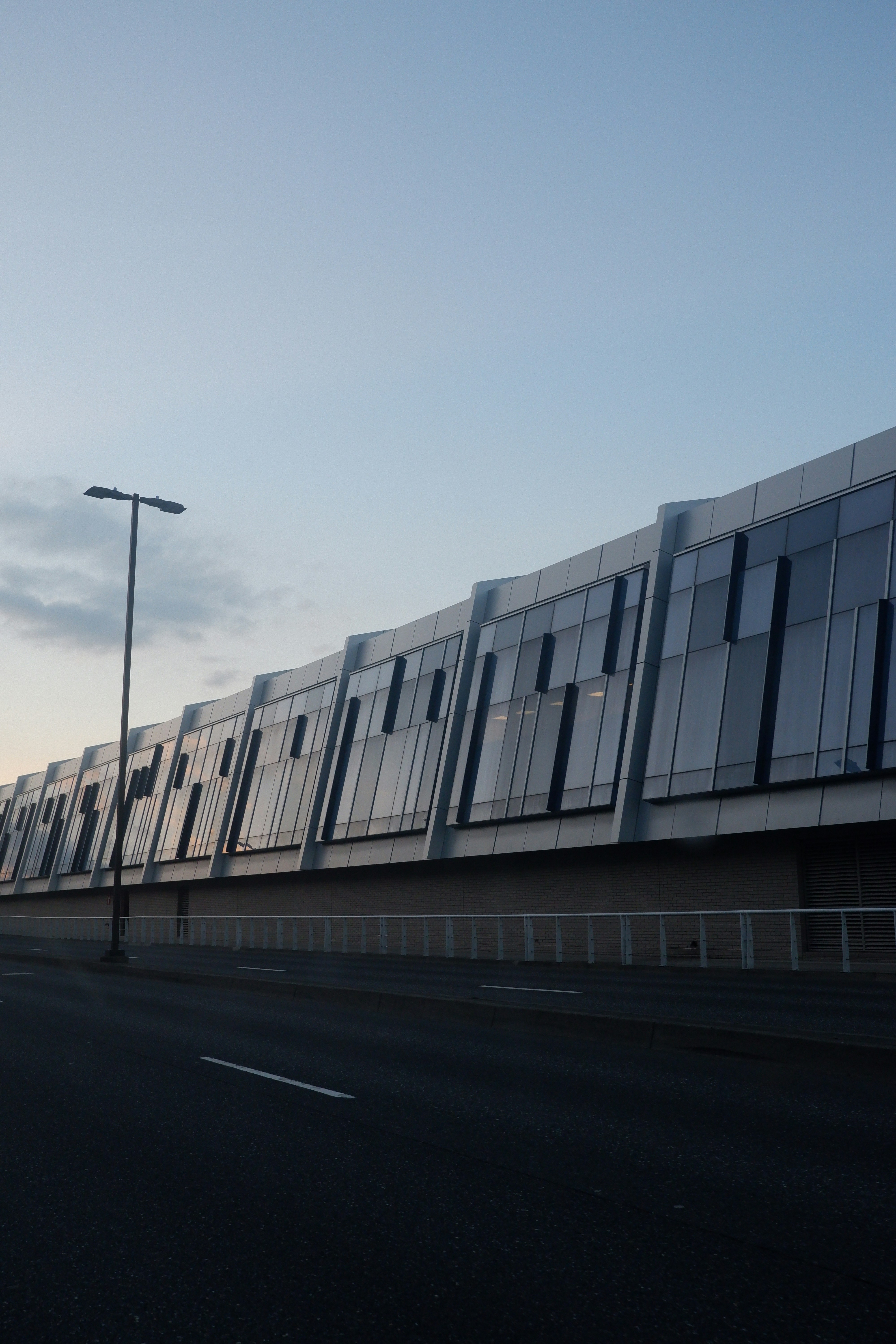 Blue Hour Facade: Parallel Panels Rise Over an Empty Street