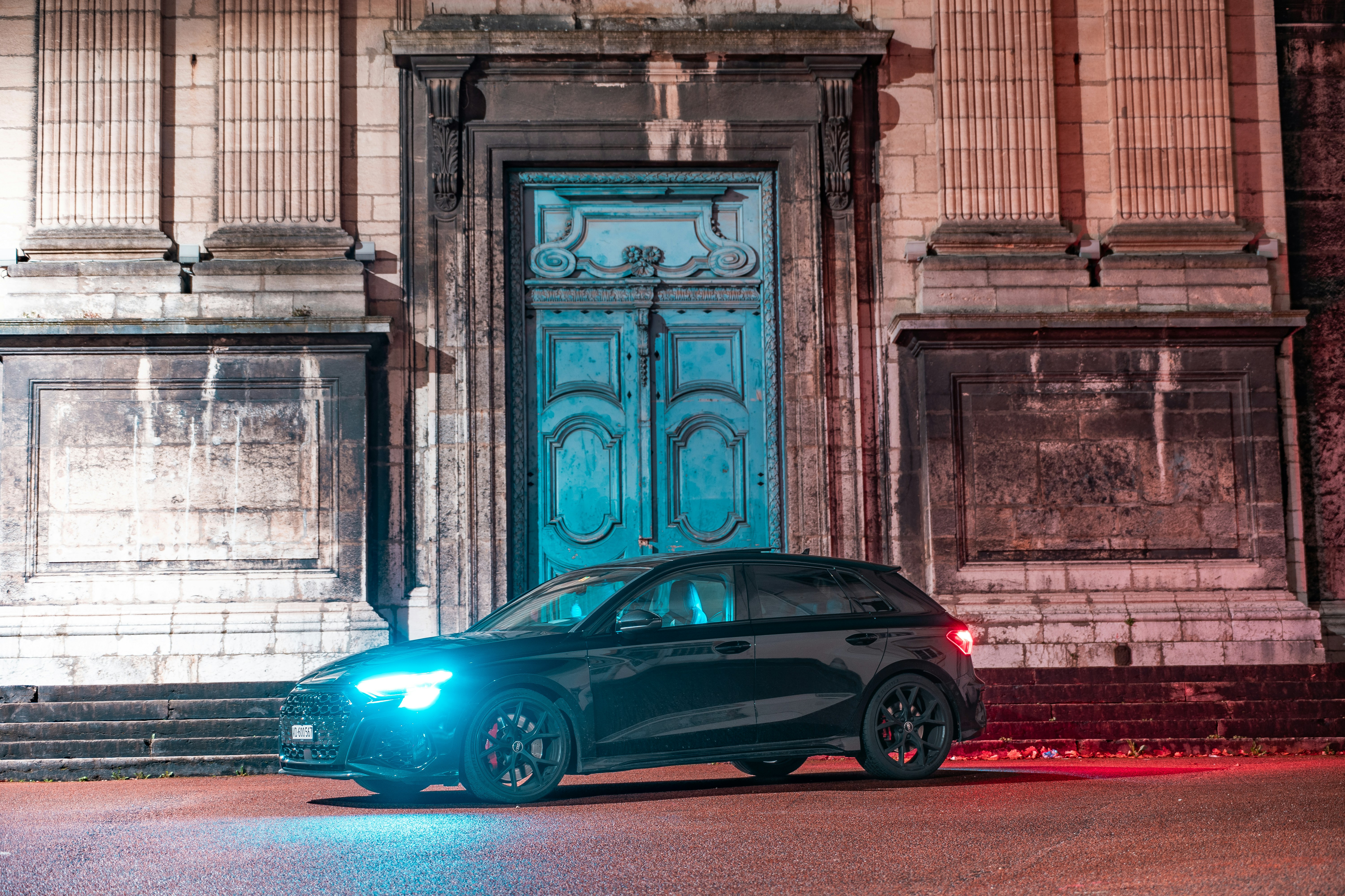 Nocturnal Sedan by a Weathered Door: Neon Blue Headlights Meet Crimson Taillights