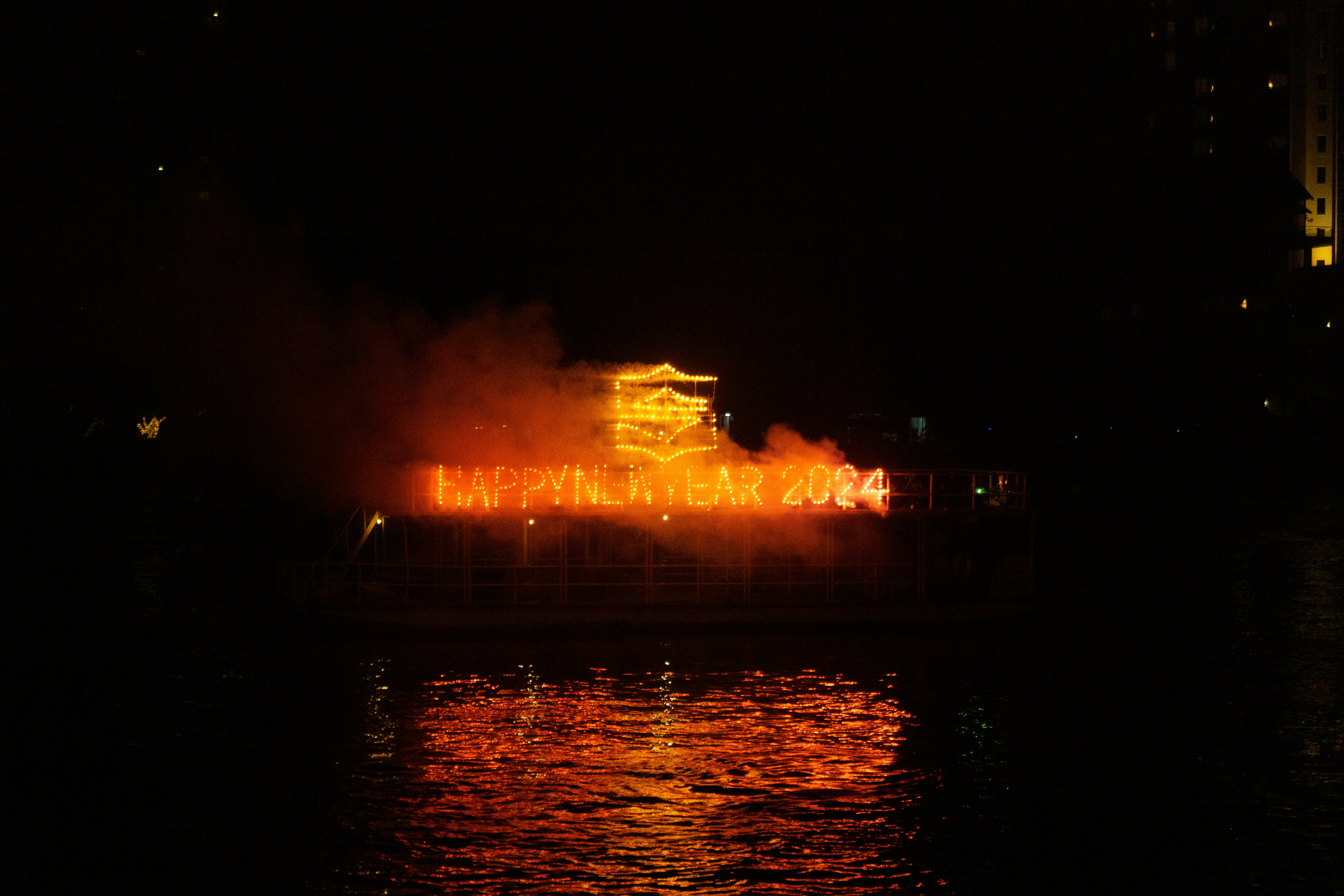 New Year’s Nightfire by the River: Amber Sign and Pagoda Glow