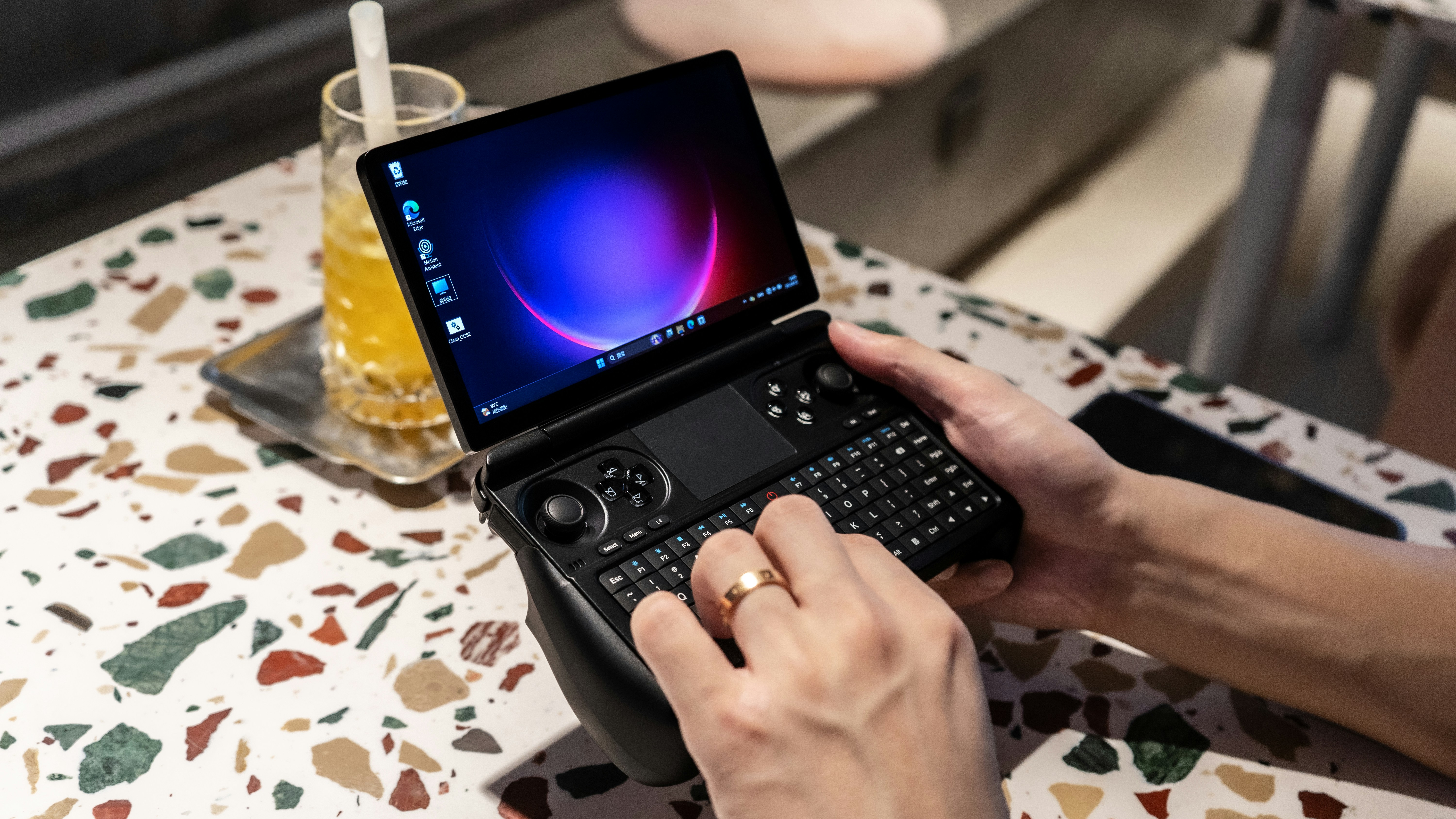 Pocket-Sized Keyboard, Big Presence: Typing on a Mini Laptop at a Terrazzo Café