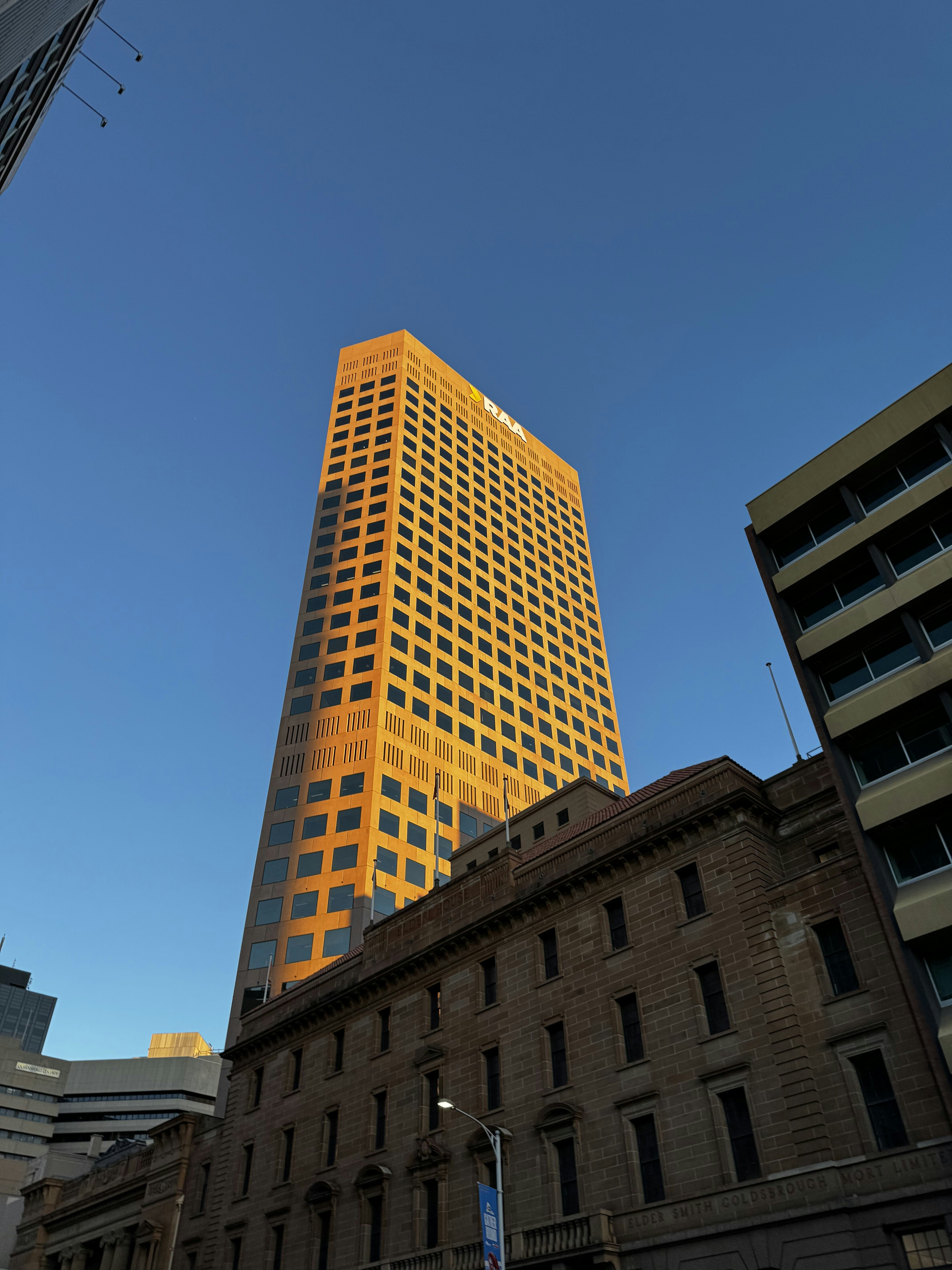 Golden Prism Over Brick: A Sunlit Tower Pierces the City