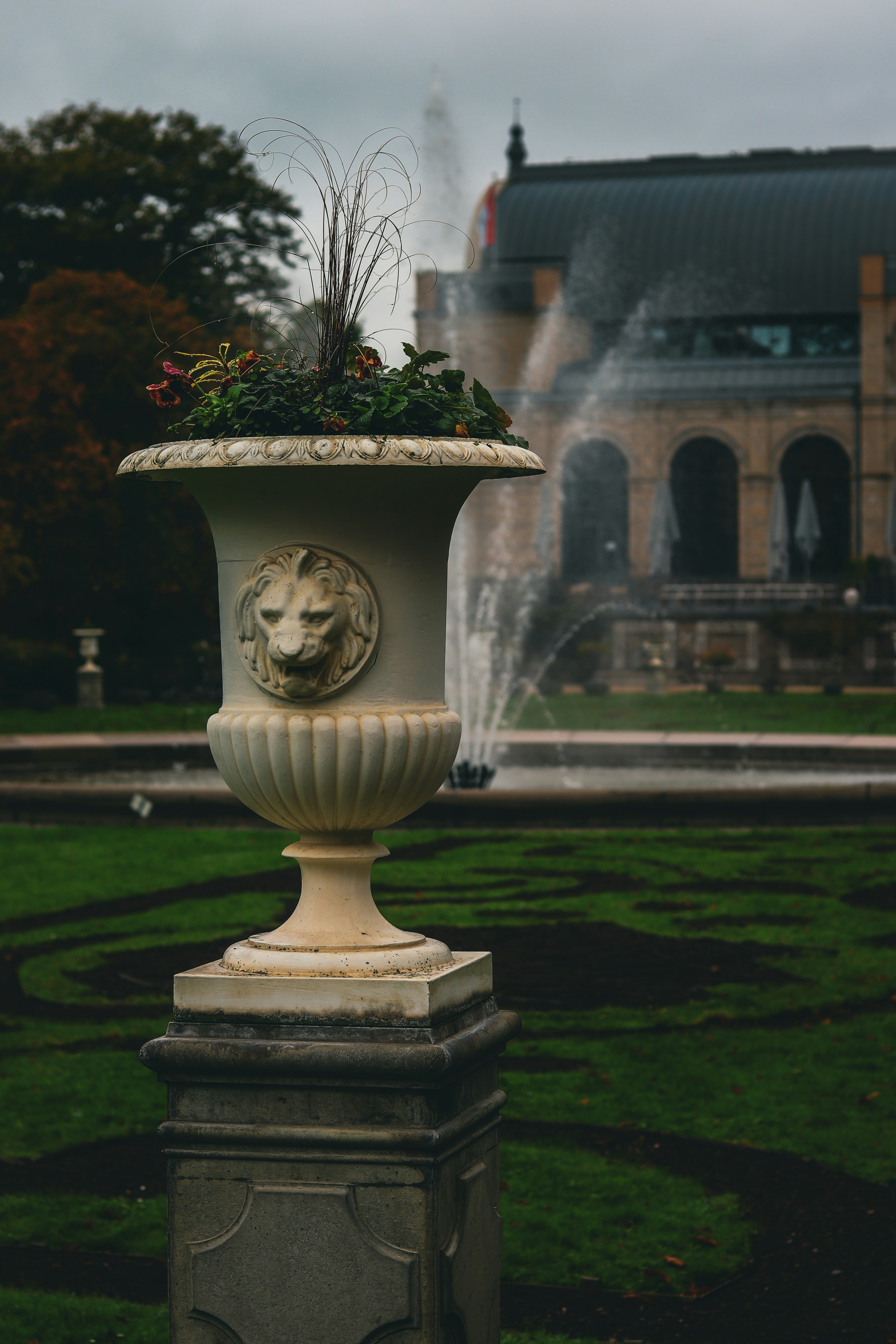 Lion Crest Planter Framing a Grand Garden Fountain