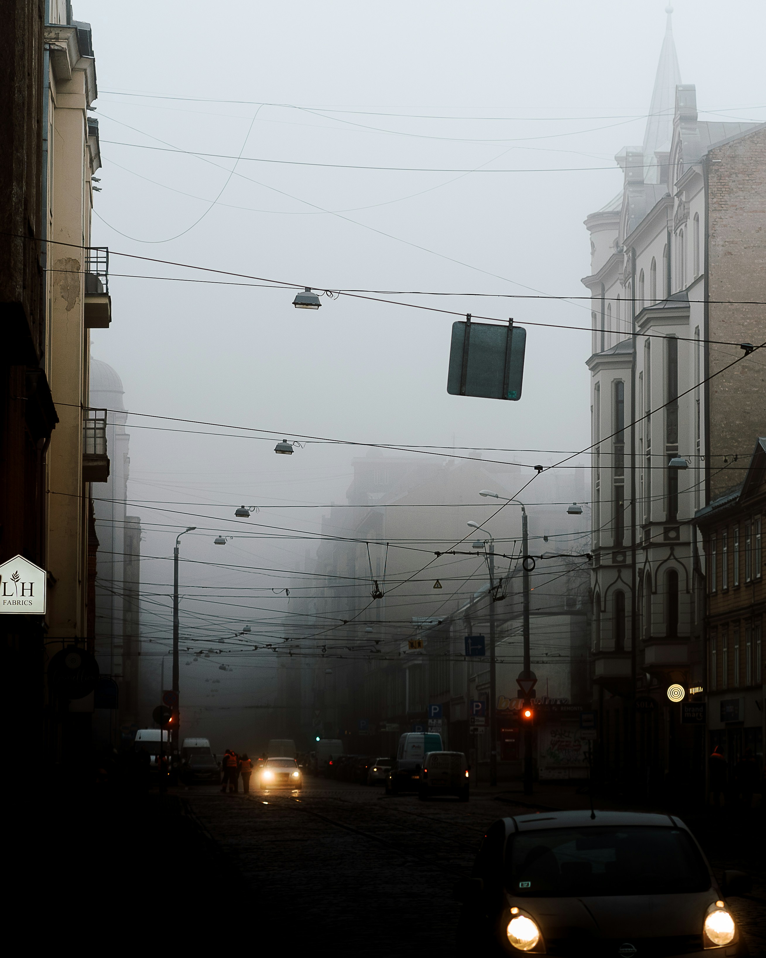 Mist-veiled Avenue: Tram Wires Weave Through a Quiet, Foggy City Street