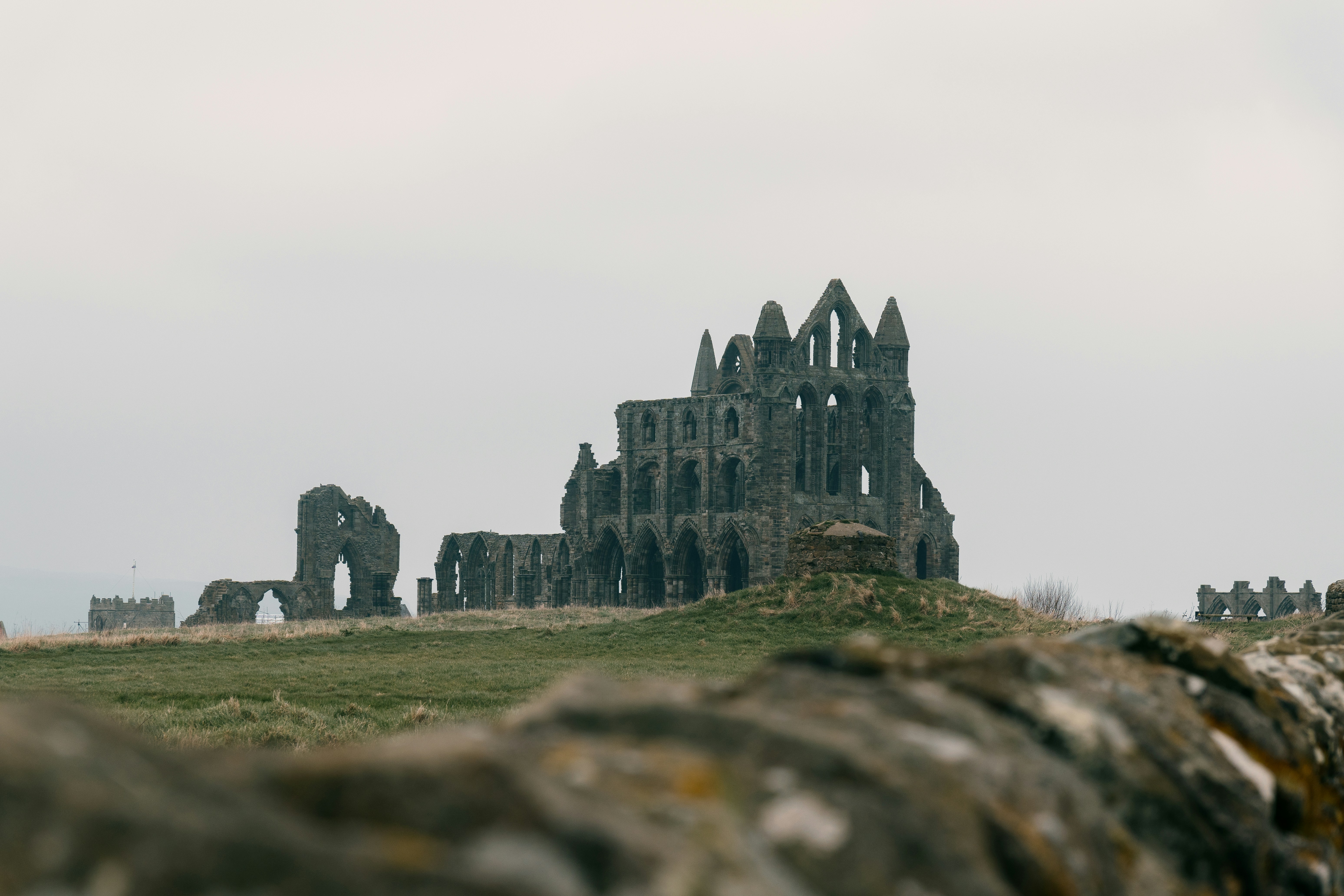 A large stone building sitting on top of a lush green field photo ...