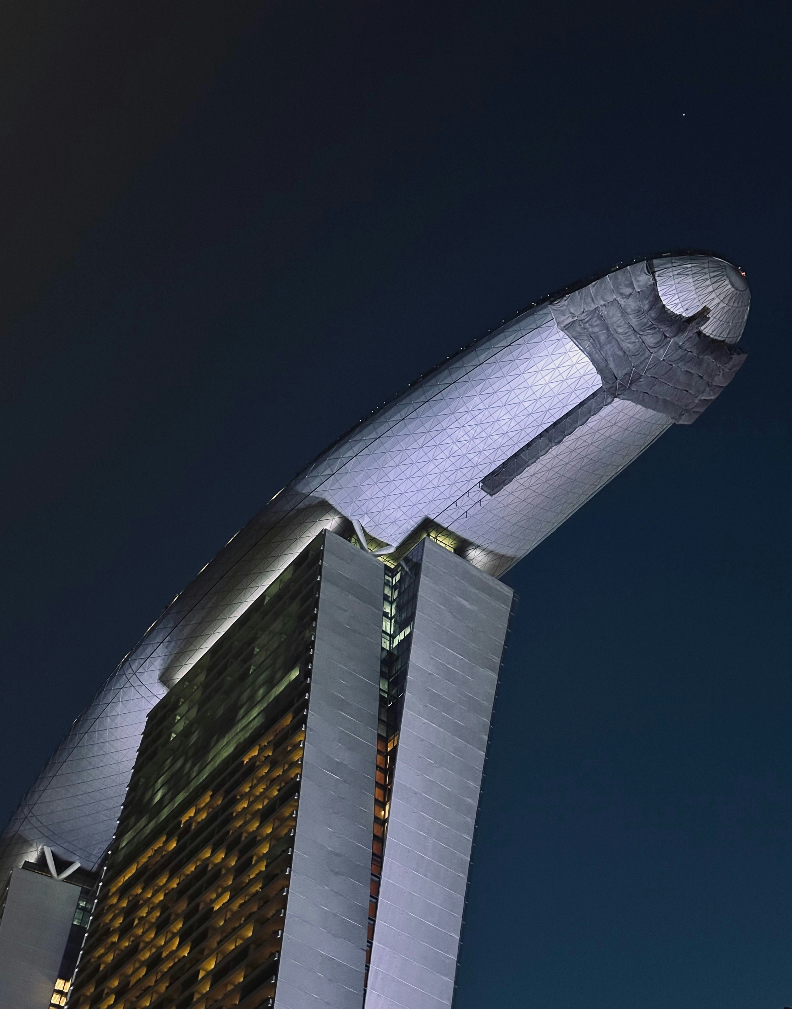 Apex in Blue: Night glow on a curved metropolis tower