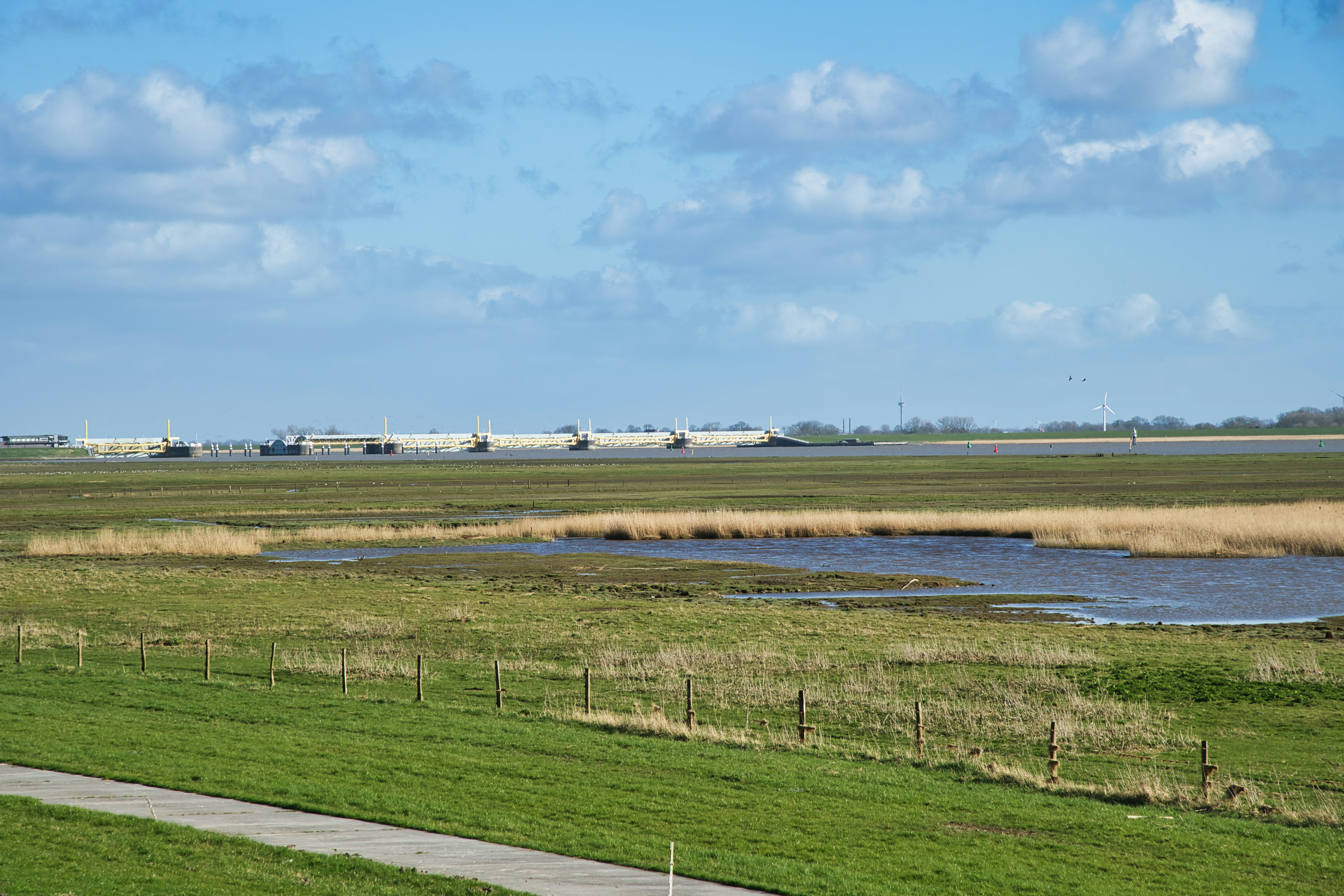 Distant Runway Across a Quiet Meadow Under a Bright Sky