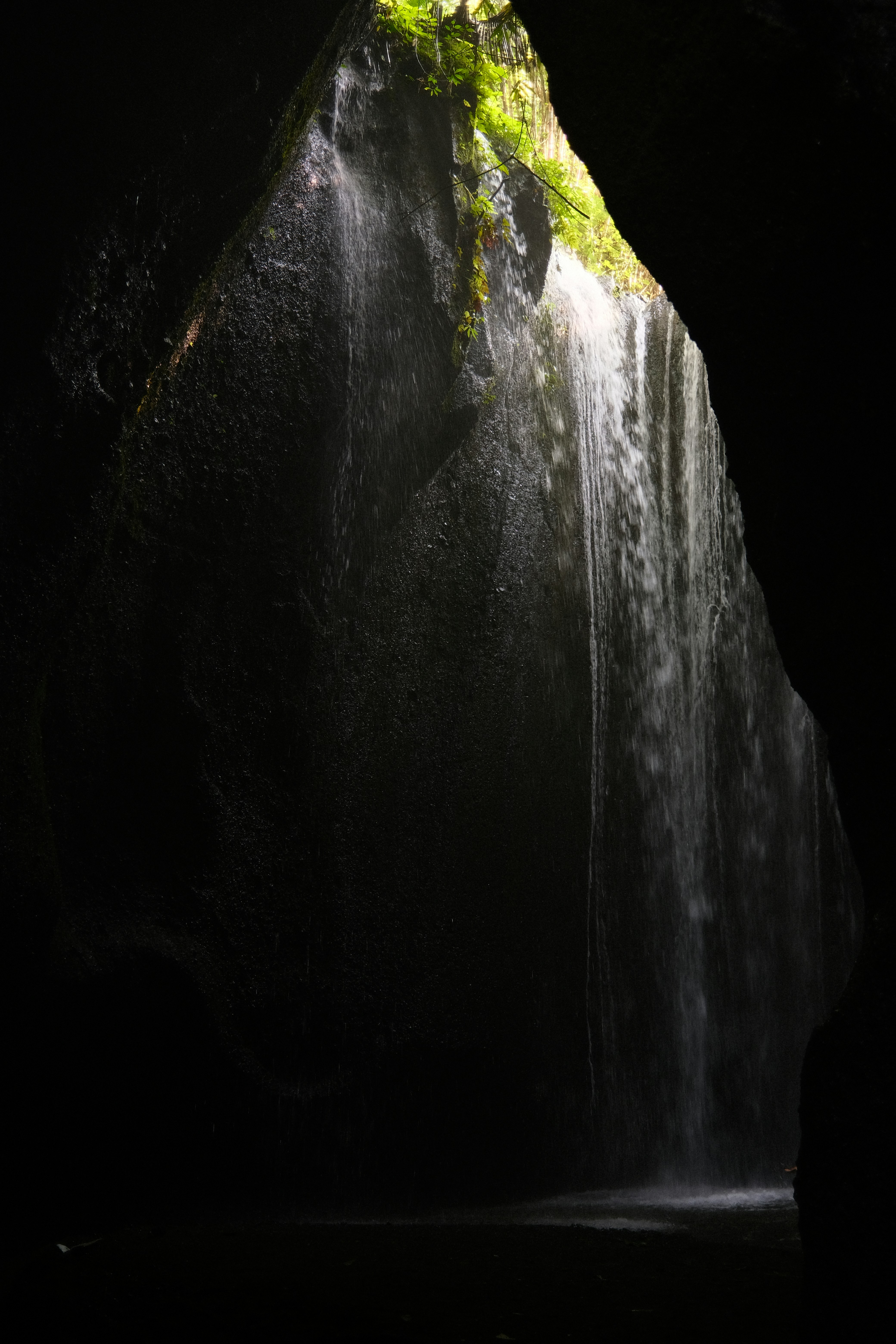 Cavern Veil: Moss-Crowned Narrow Waterfall in Soft Light