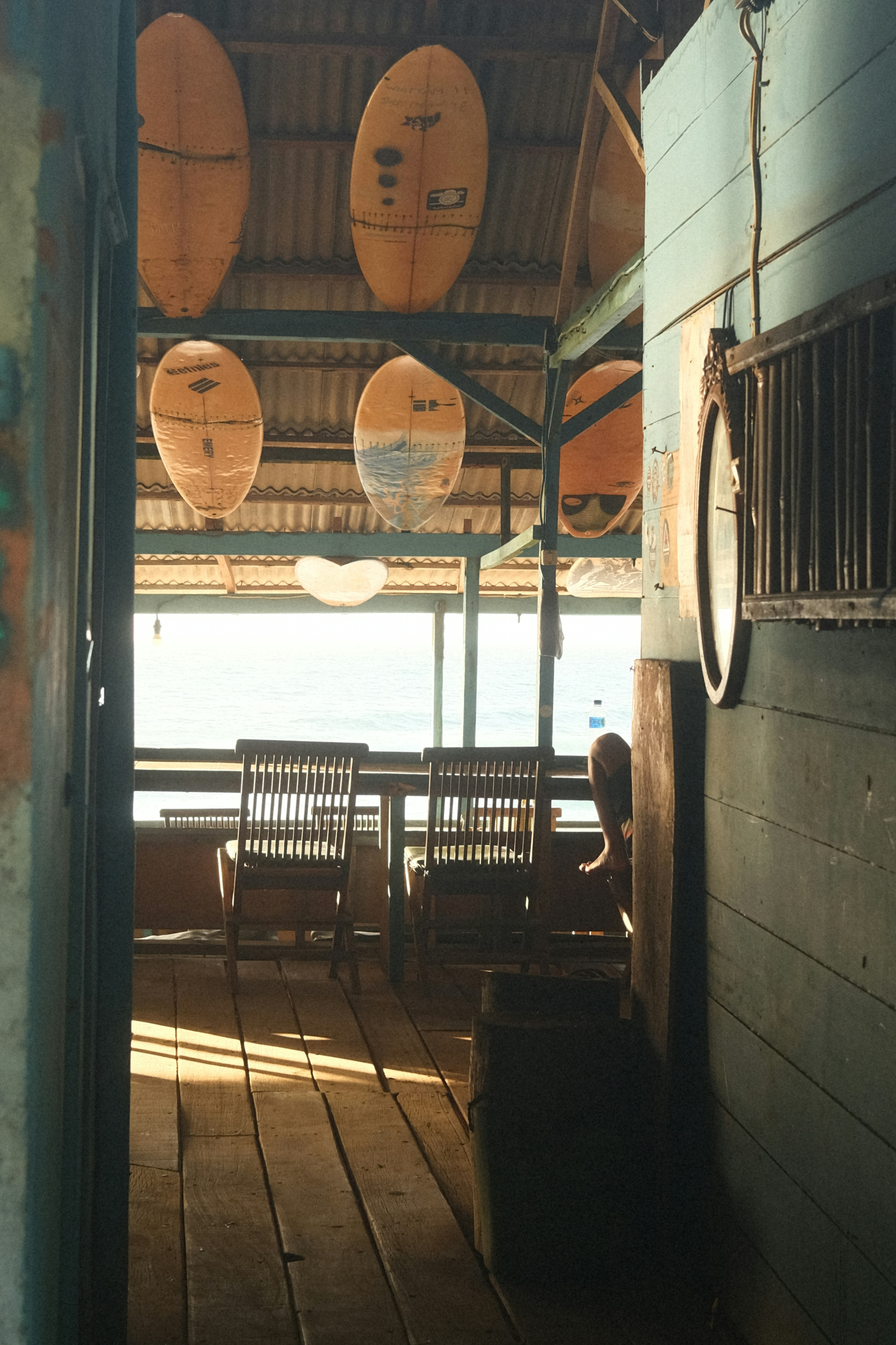 Sea-window Lounge: Sunlit Surf Shack with Suspended Boards and Seaside Seating