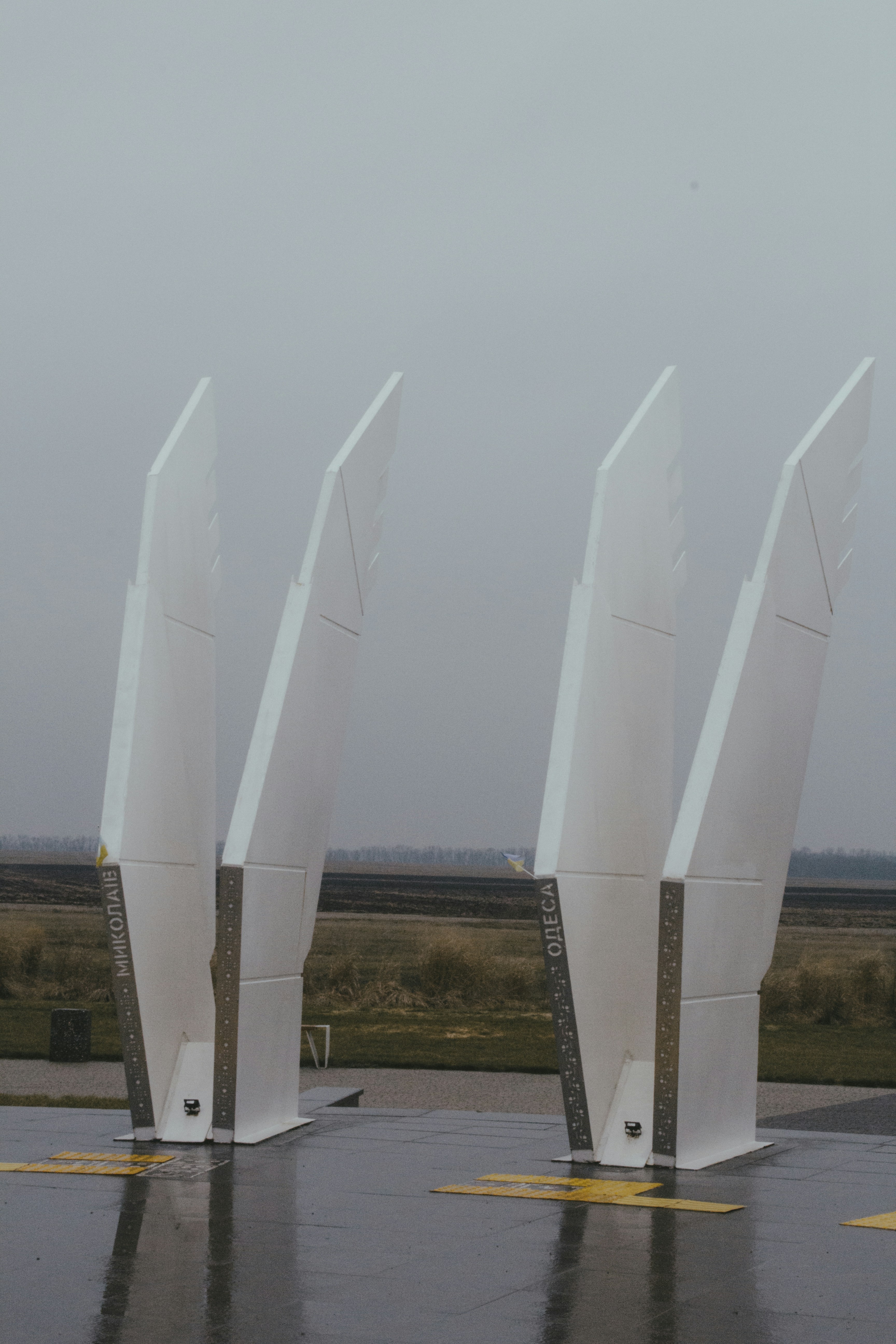 Winglet silhouettes: a quartet of white fins on a misty runway