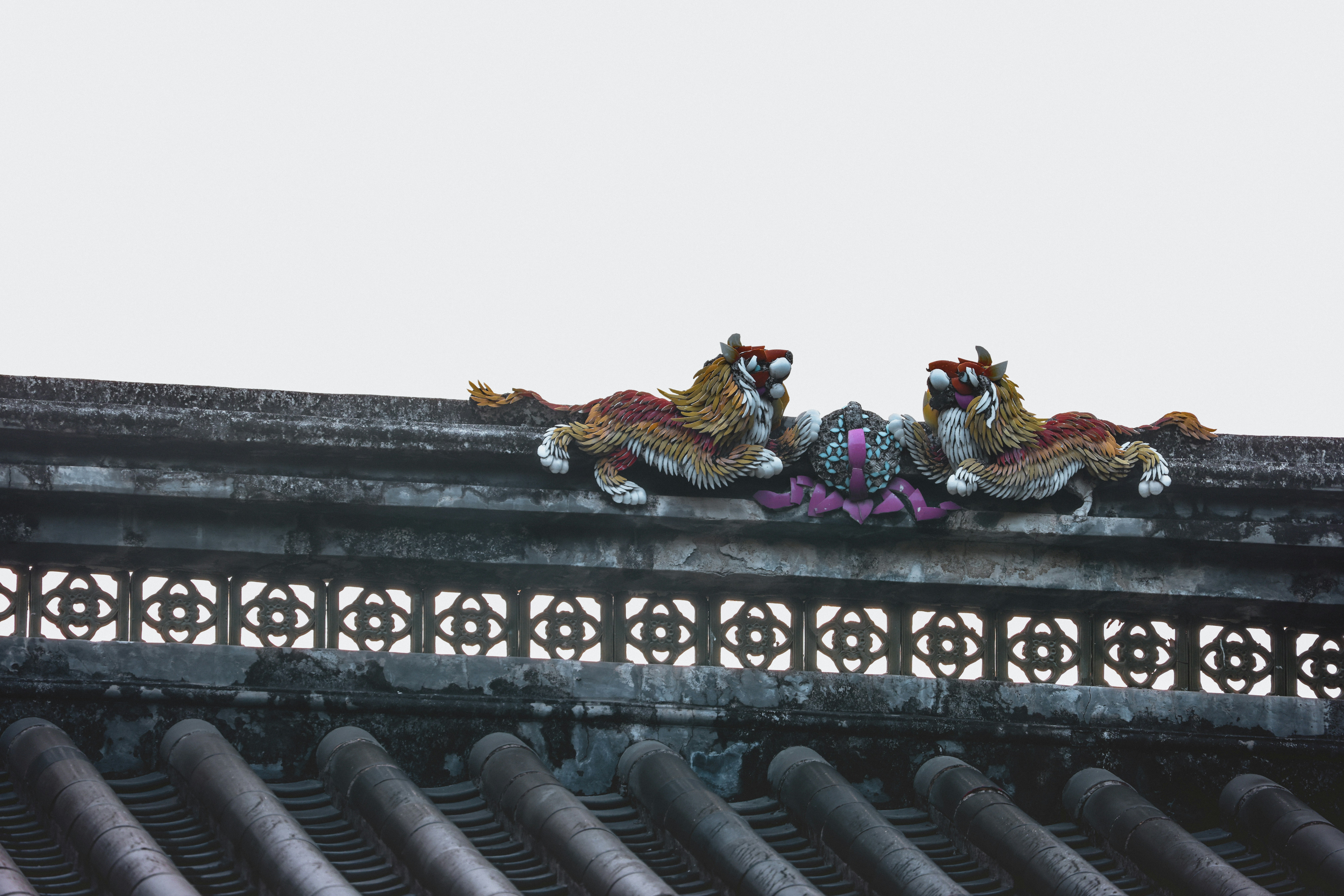 two dragon statues on the roof of a building