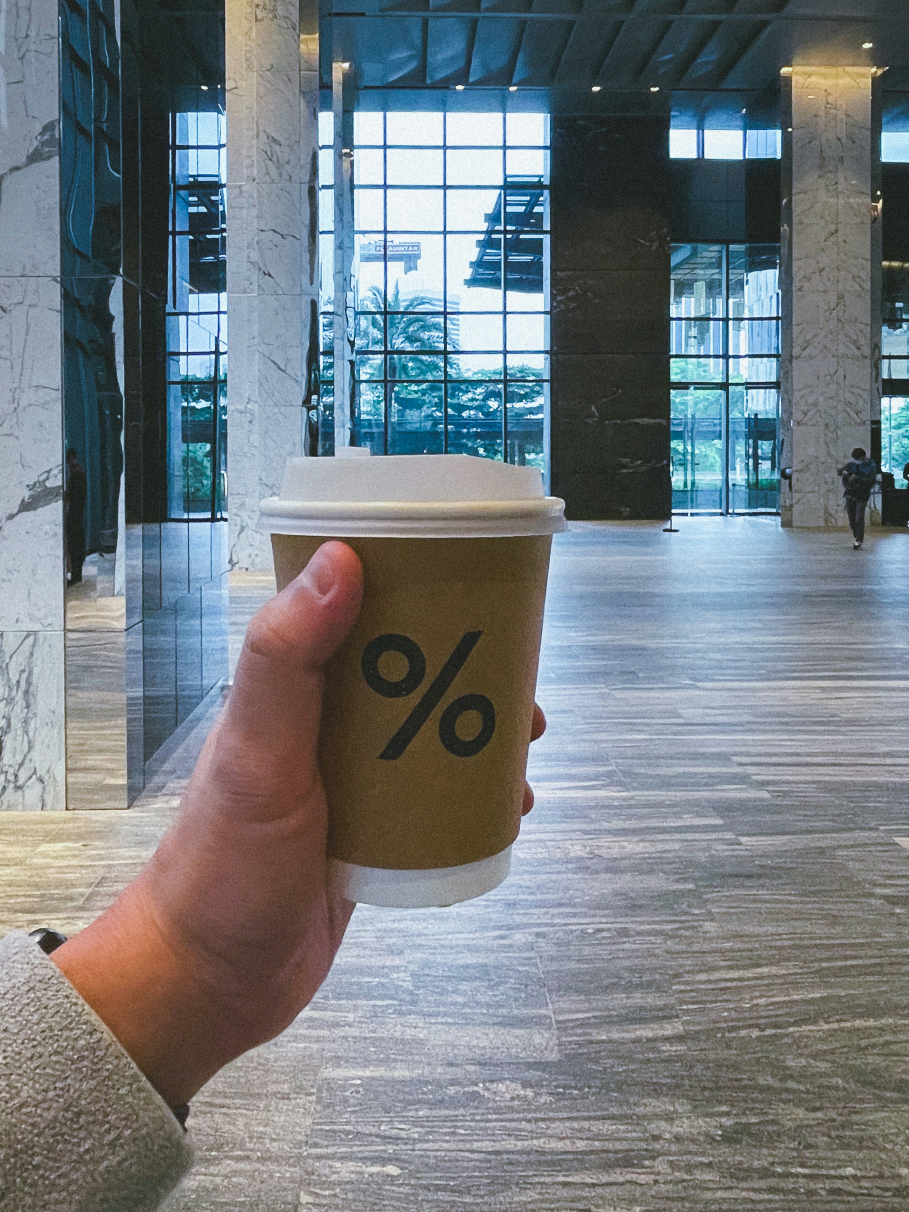 A hand holding a cup of coffee with a percentage sign on it photo ...