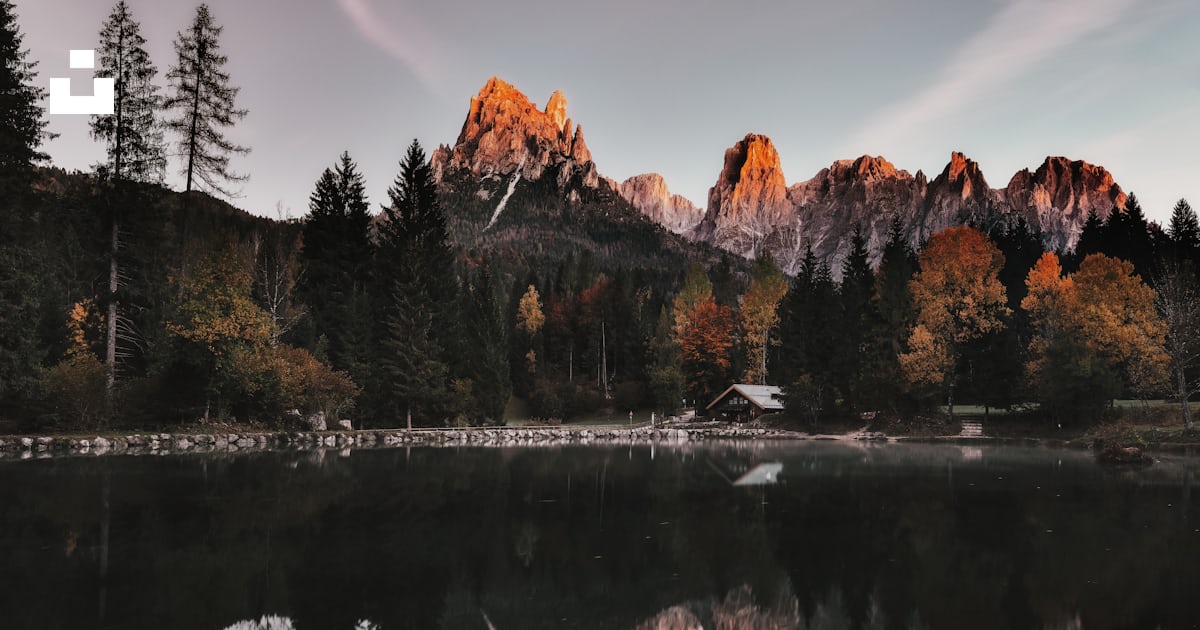 木々に囲まれた湖と山々を背景にの写真 Unsplashの無料自然写真