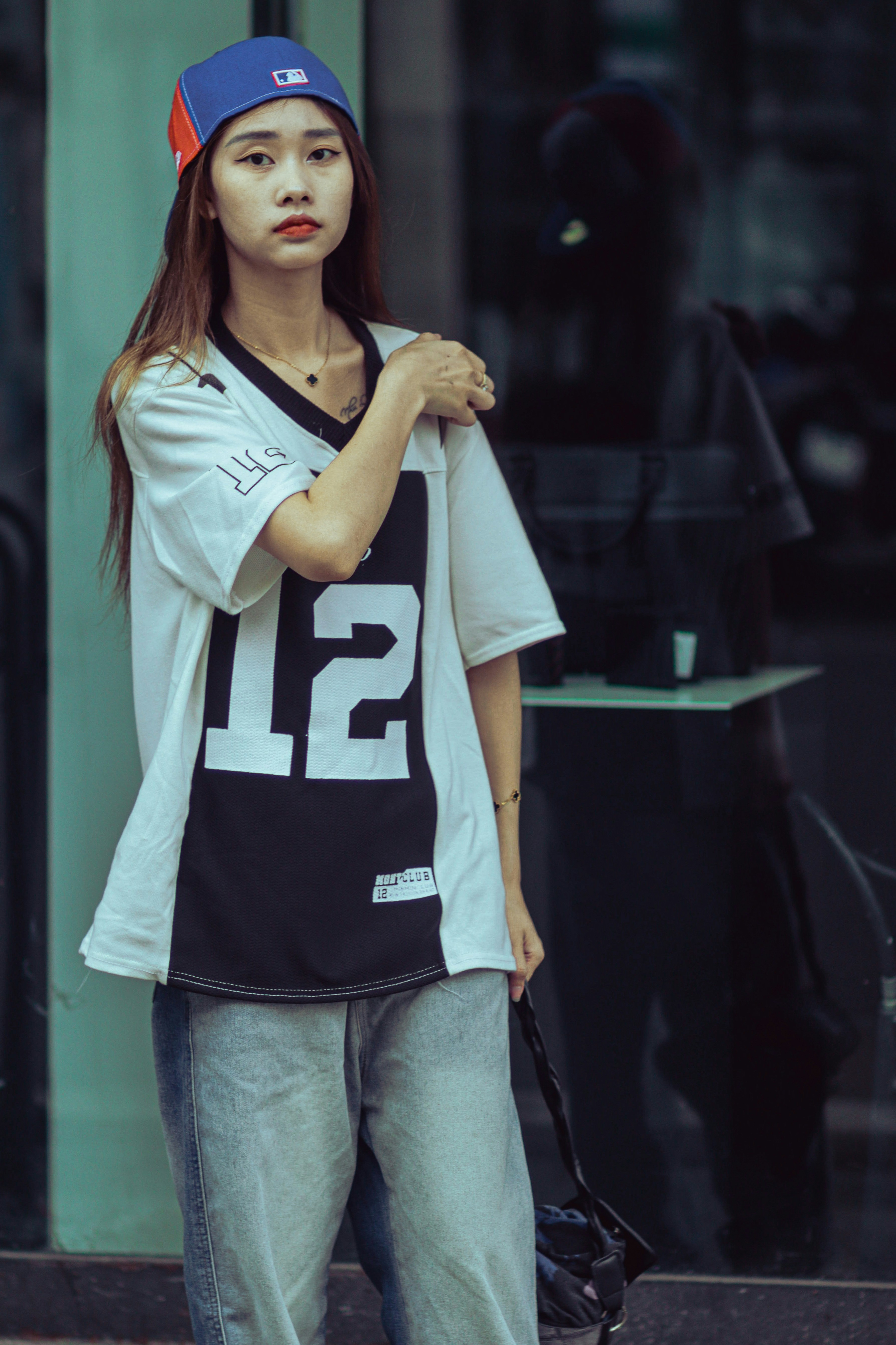 Foto Una mujer parada en la calle con una gorra de béisbol puesta – Imagen Vietnam gratis en ...