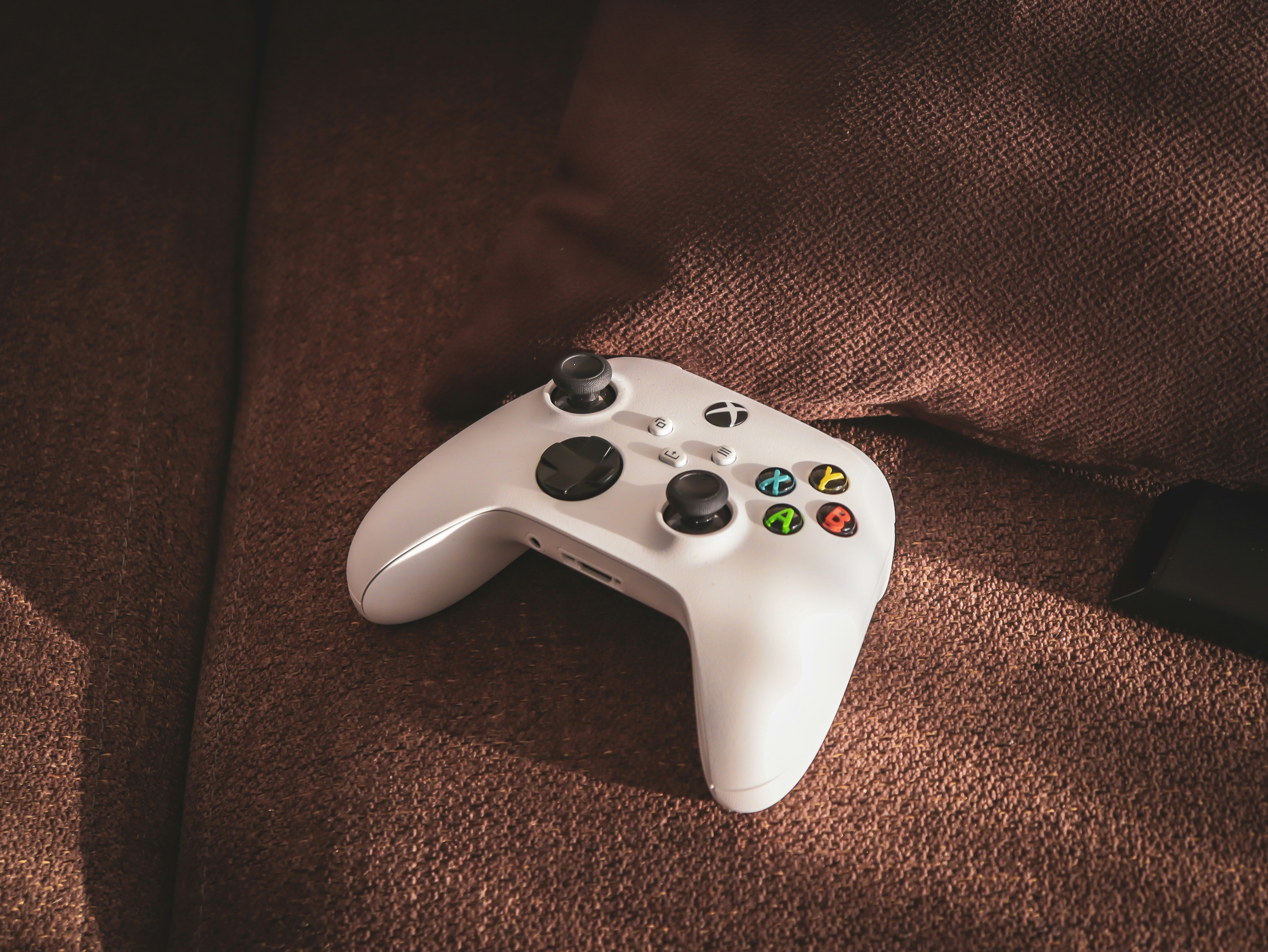 A white controller sitting on top of a couch photo – Free Electronics ...
