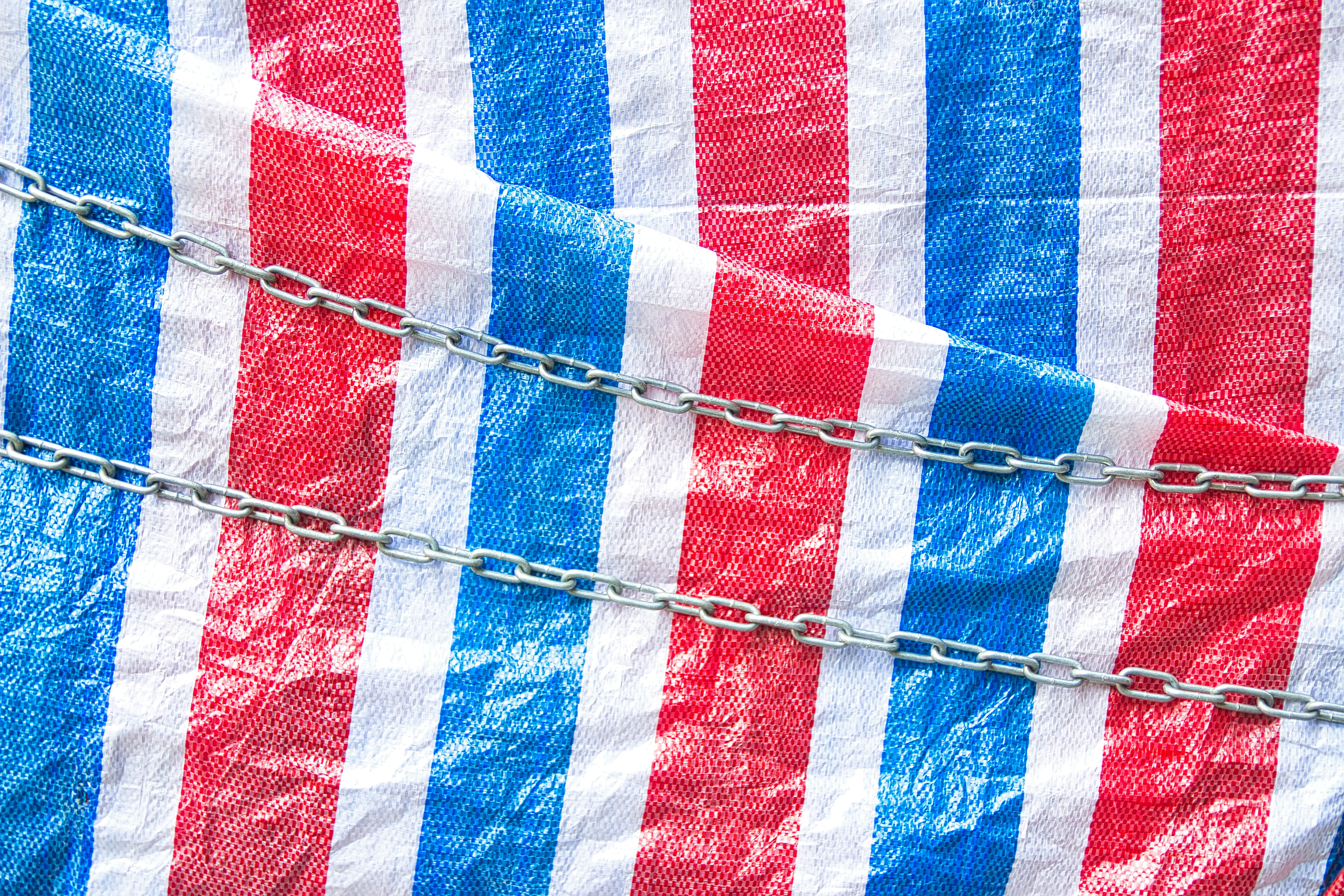 A red, white and blue flag with a chain link fence photo – Free Image ...