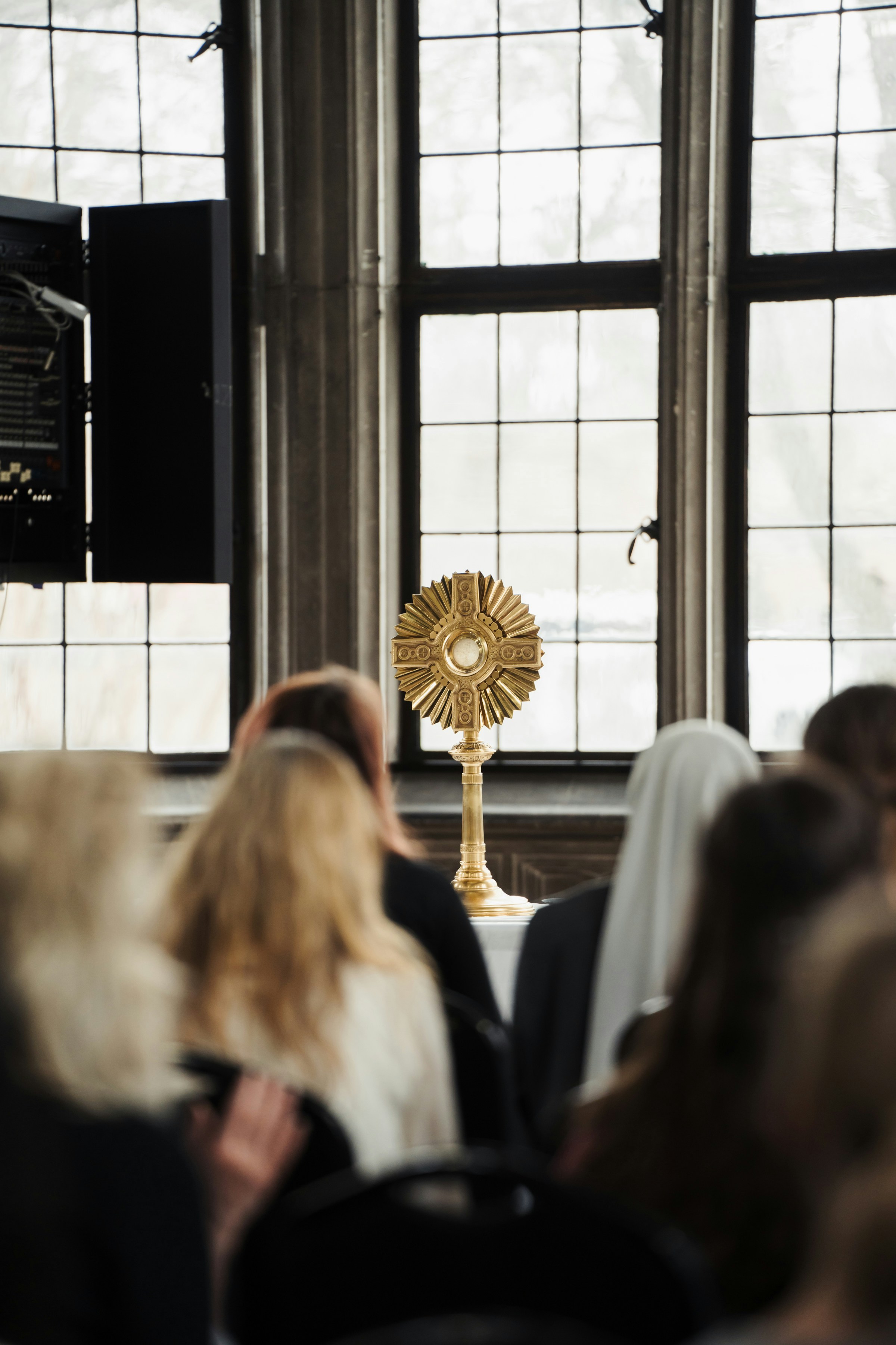 Gold Monstrance Under Windowed Light: Quiet Reverence in a Cathedral Hall