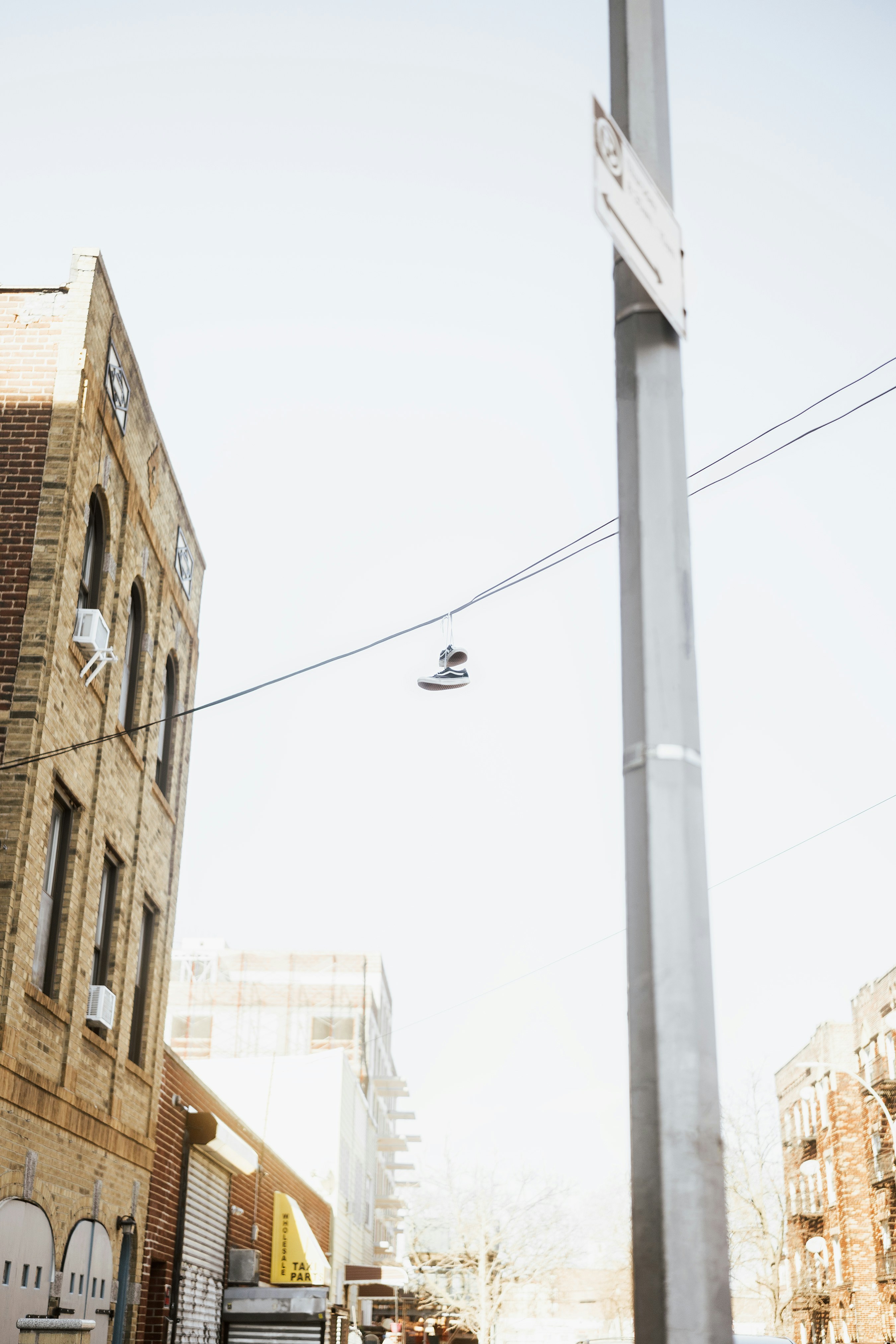 Quiet Urban Facade: A Leaning Streetlight Framed by Brick Buildings