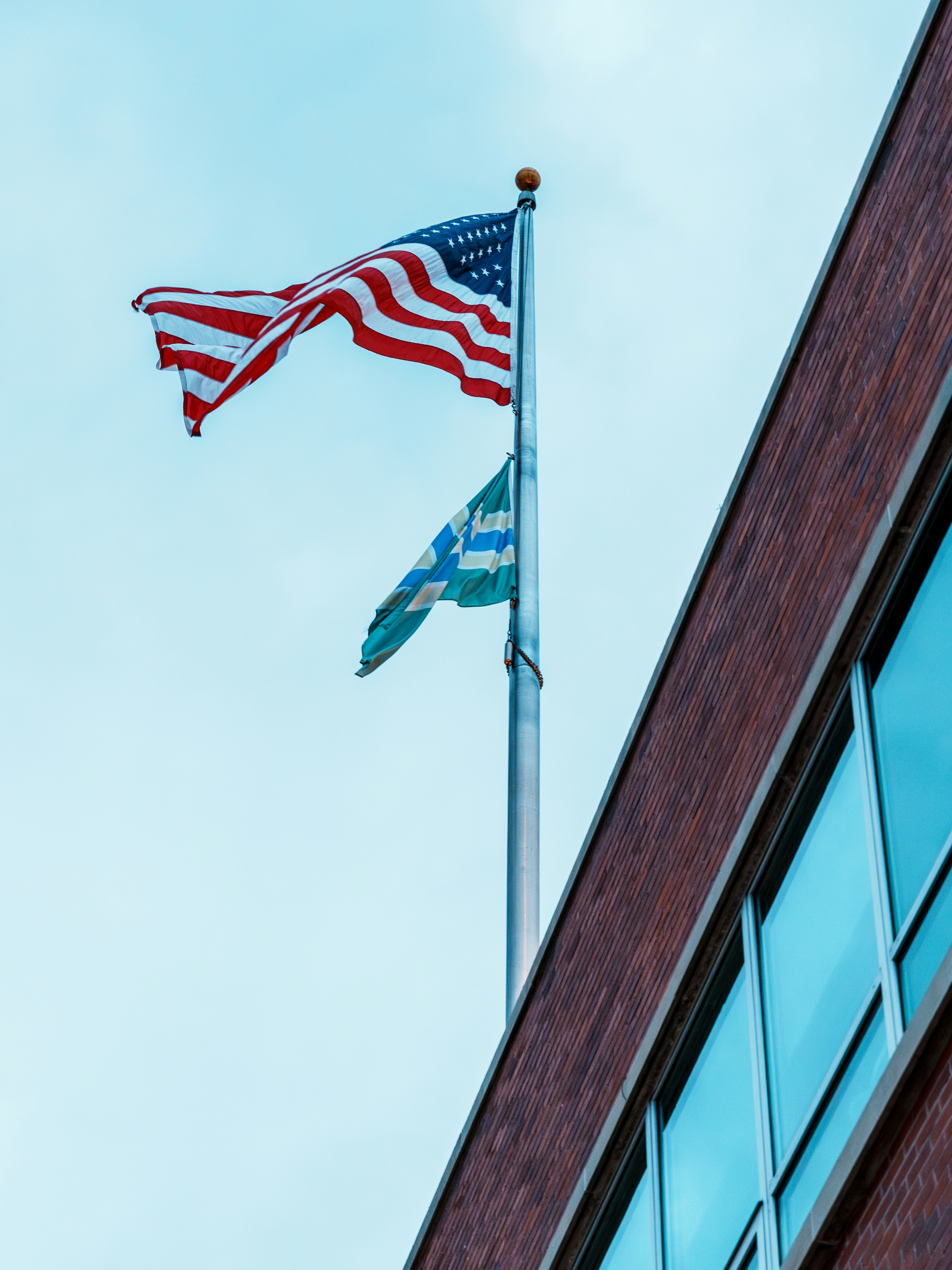 Foto Dos banderas ondeando una al lado de la otra en lo alto de un ...