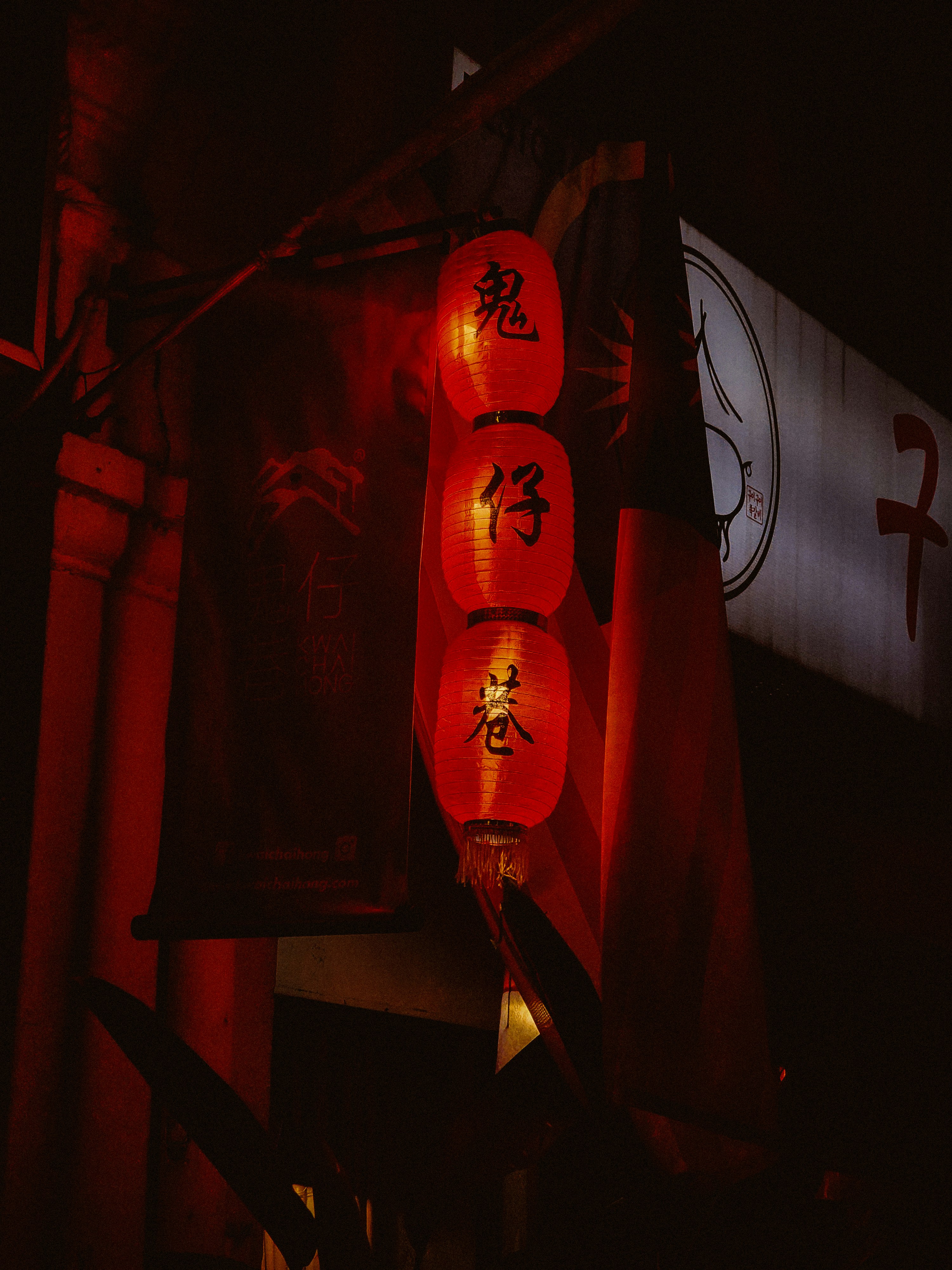 A red light hanging from the side of a building photo – Free Woman ...
