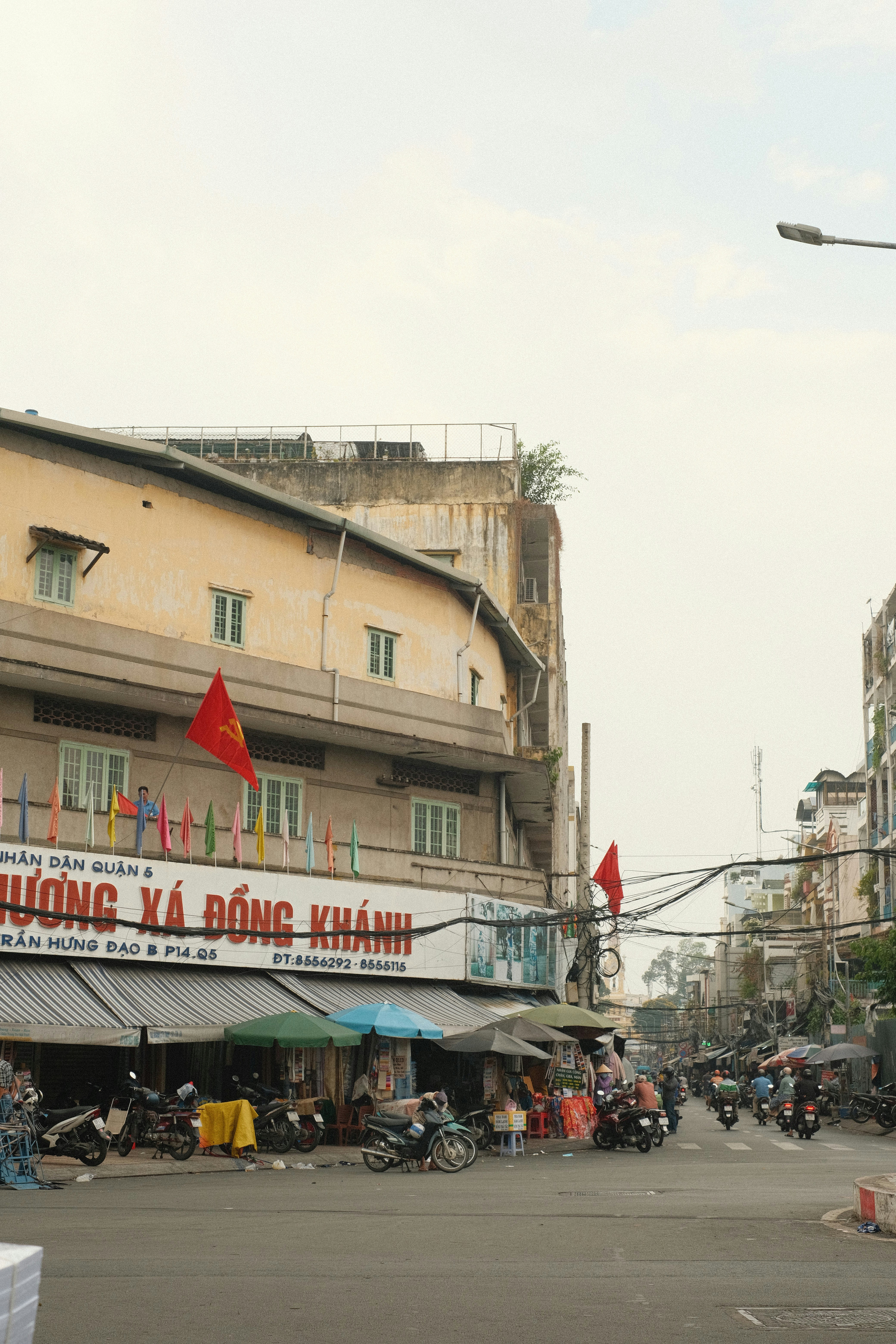 Sunlit Street Market: Yellow Facades, Red Flags, and a City Pulse