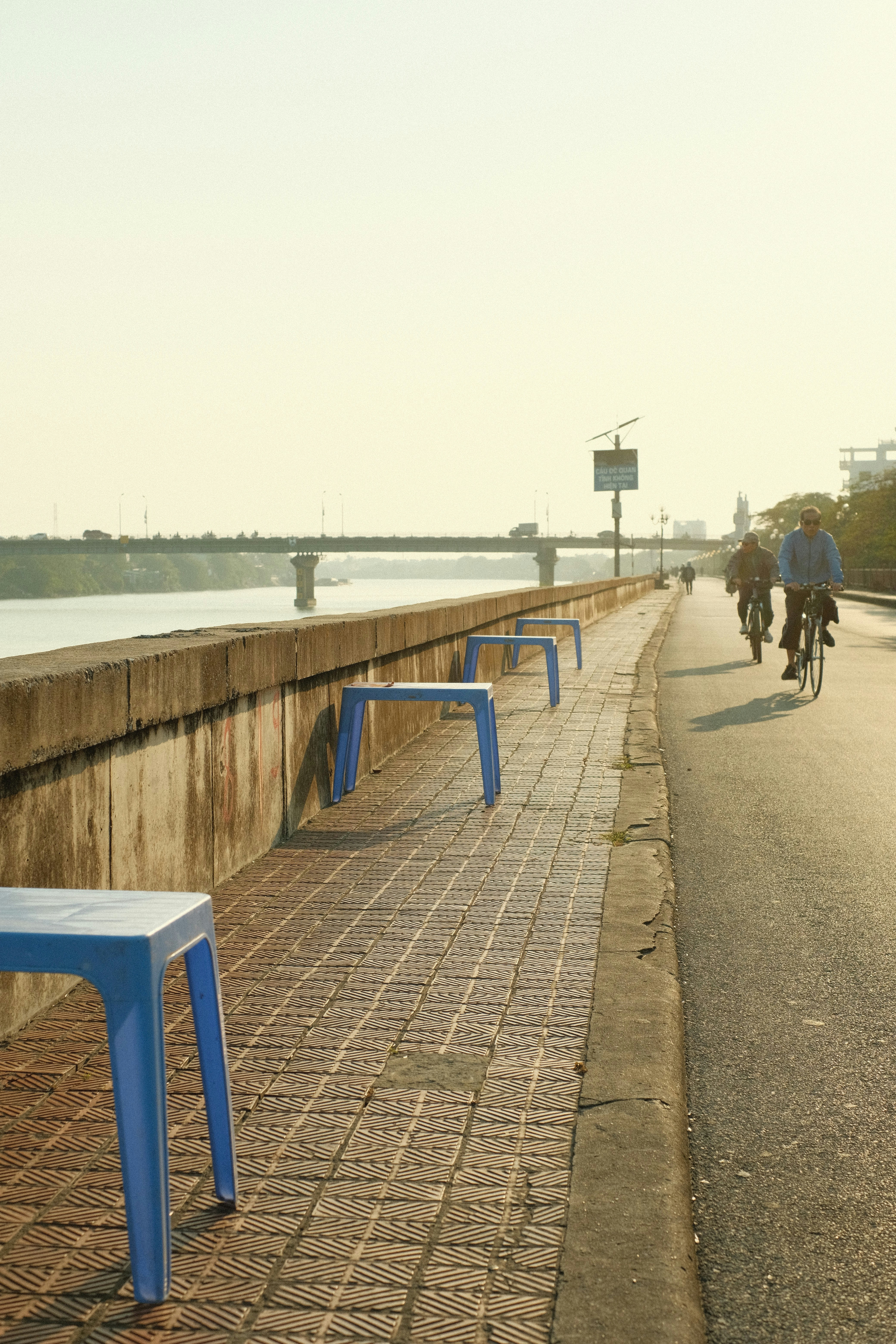 Pastel Riverside: Blue Benches Lead the Quiet Promenade