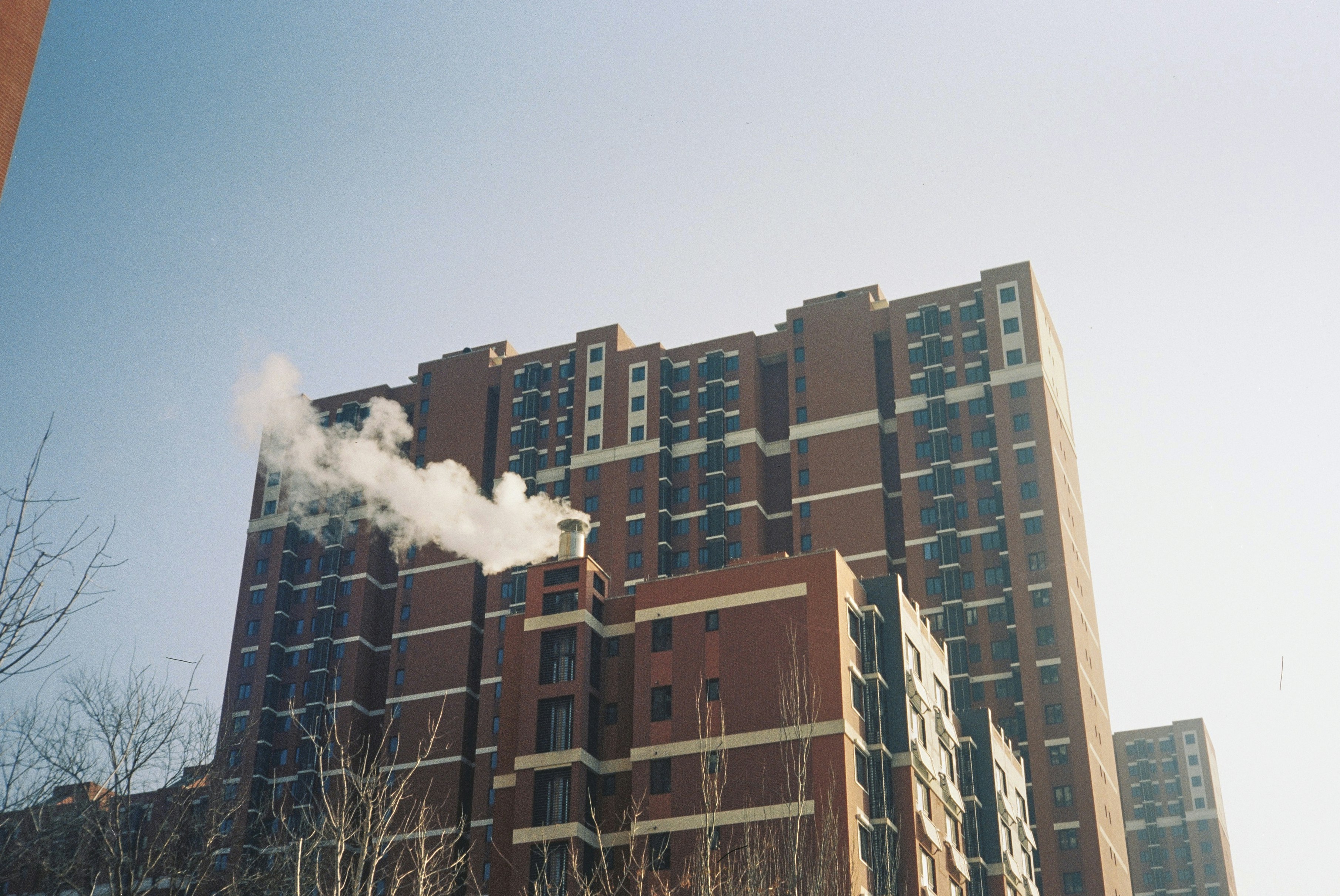 Brick-Tower Steam: A Quiet Exhale Over a Clear Sky