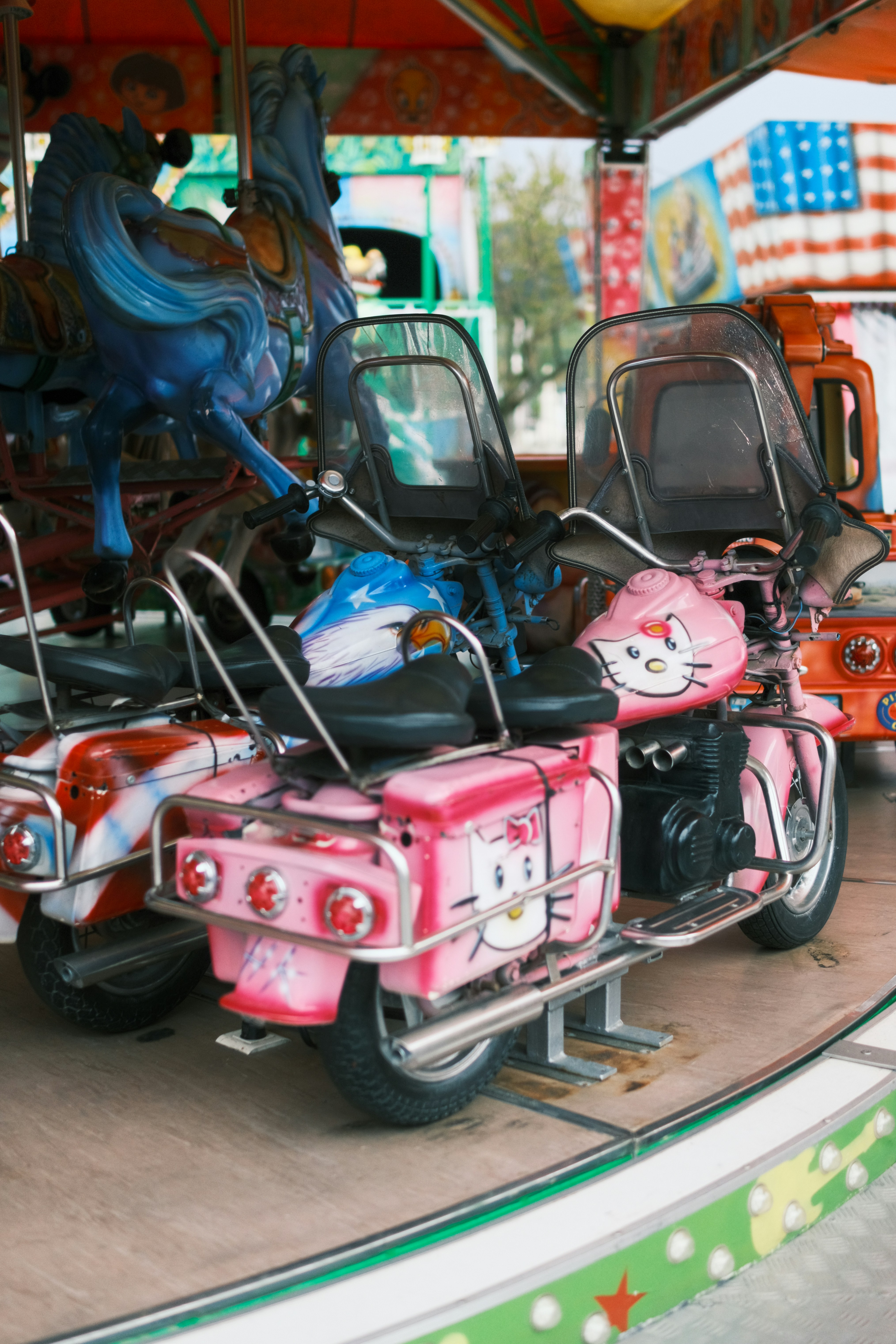 A carnival ride with a pink motorcycle and other vehicles photo – Free ...