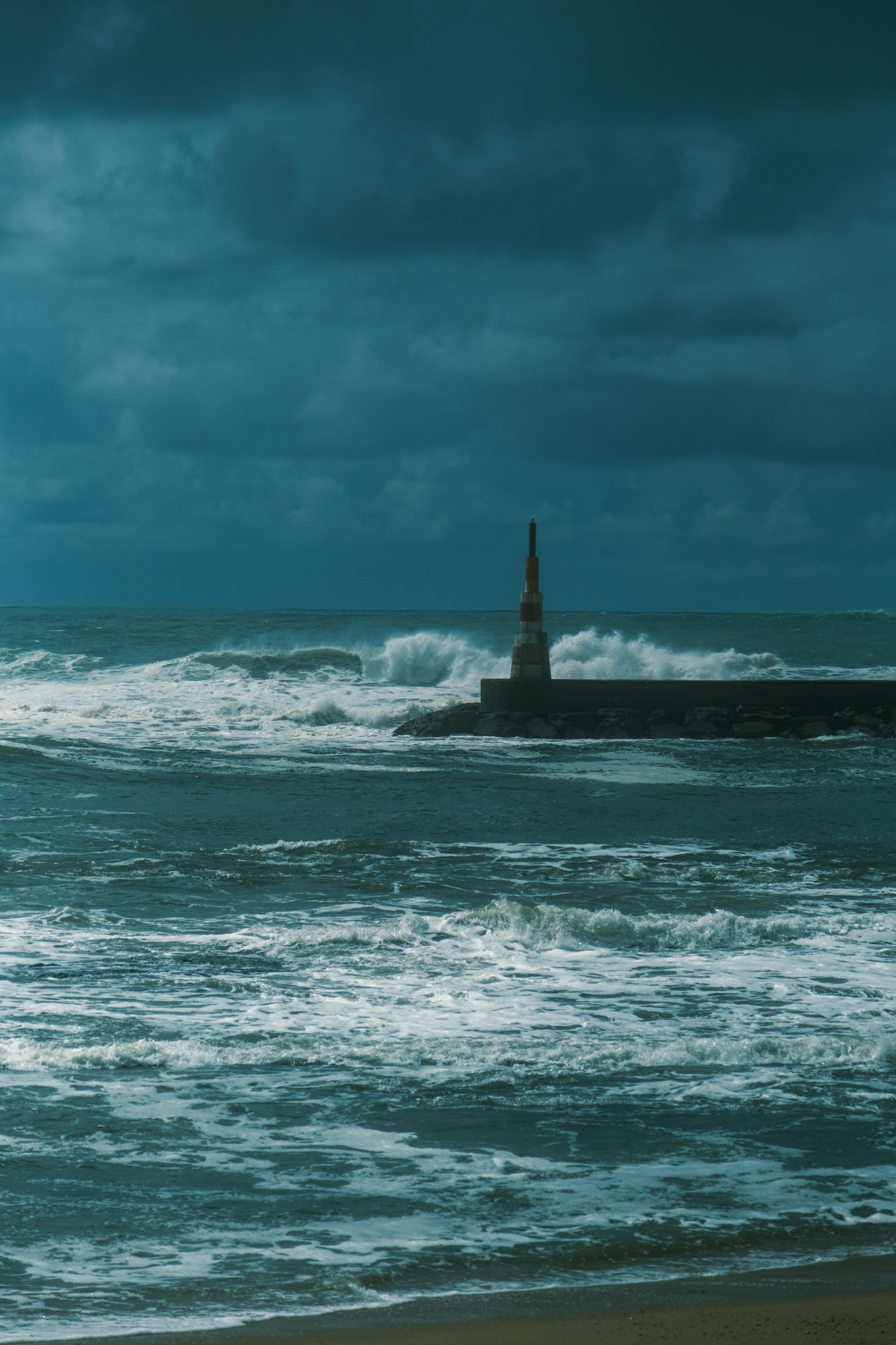 Teal Sentinel: Lighthouse Pier Braving a Turbulent Sea