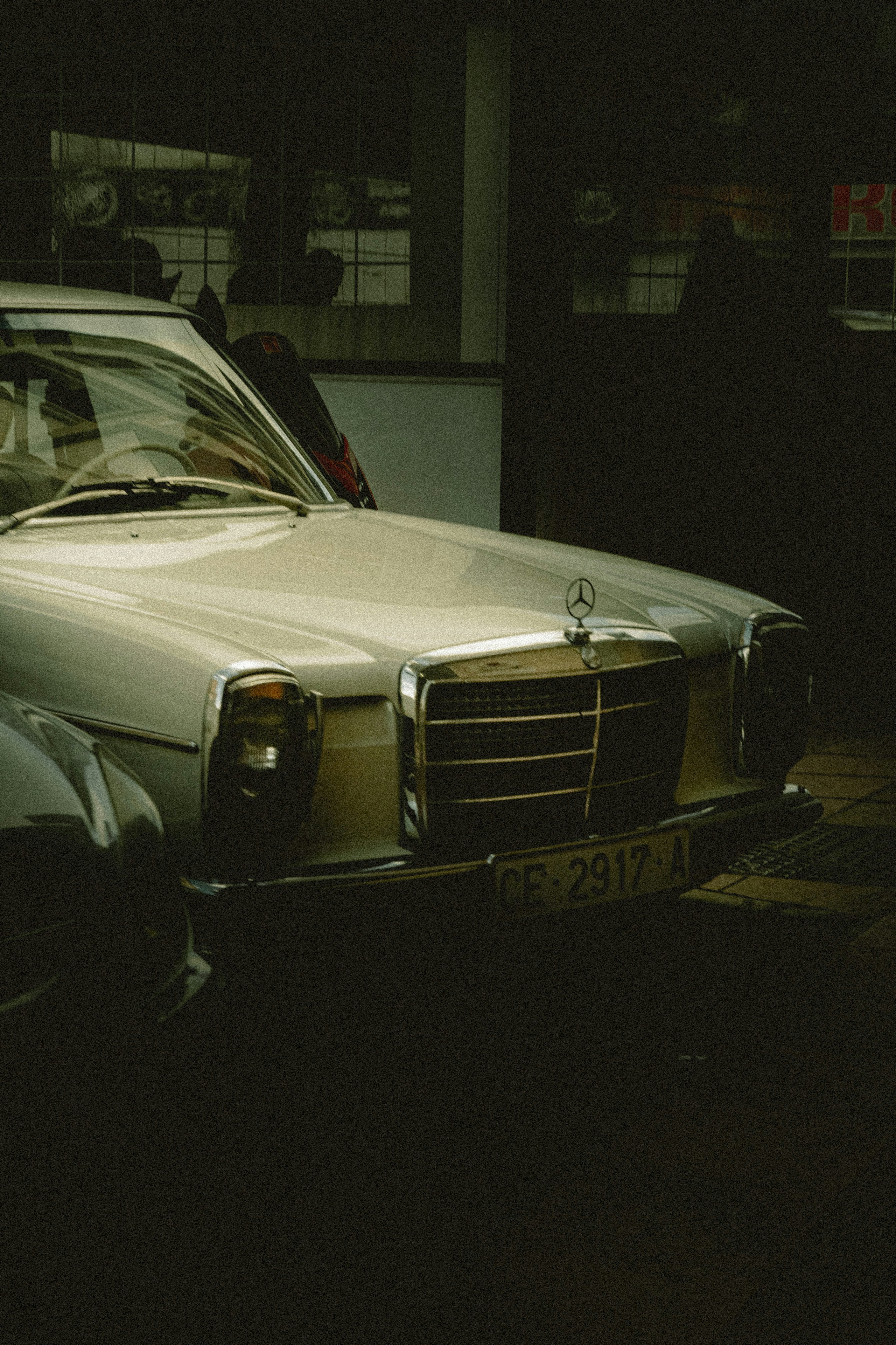 Low-Light Chrome: Front View of a Classic Mercedes in a Dim Garage