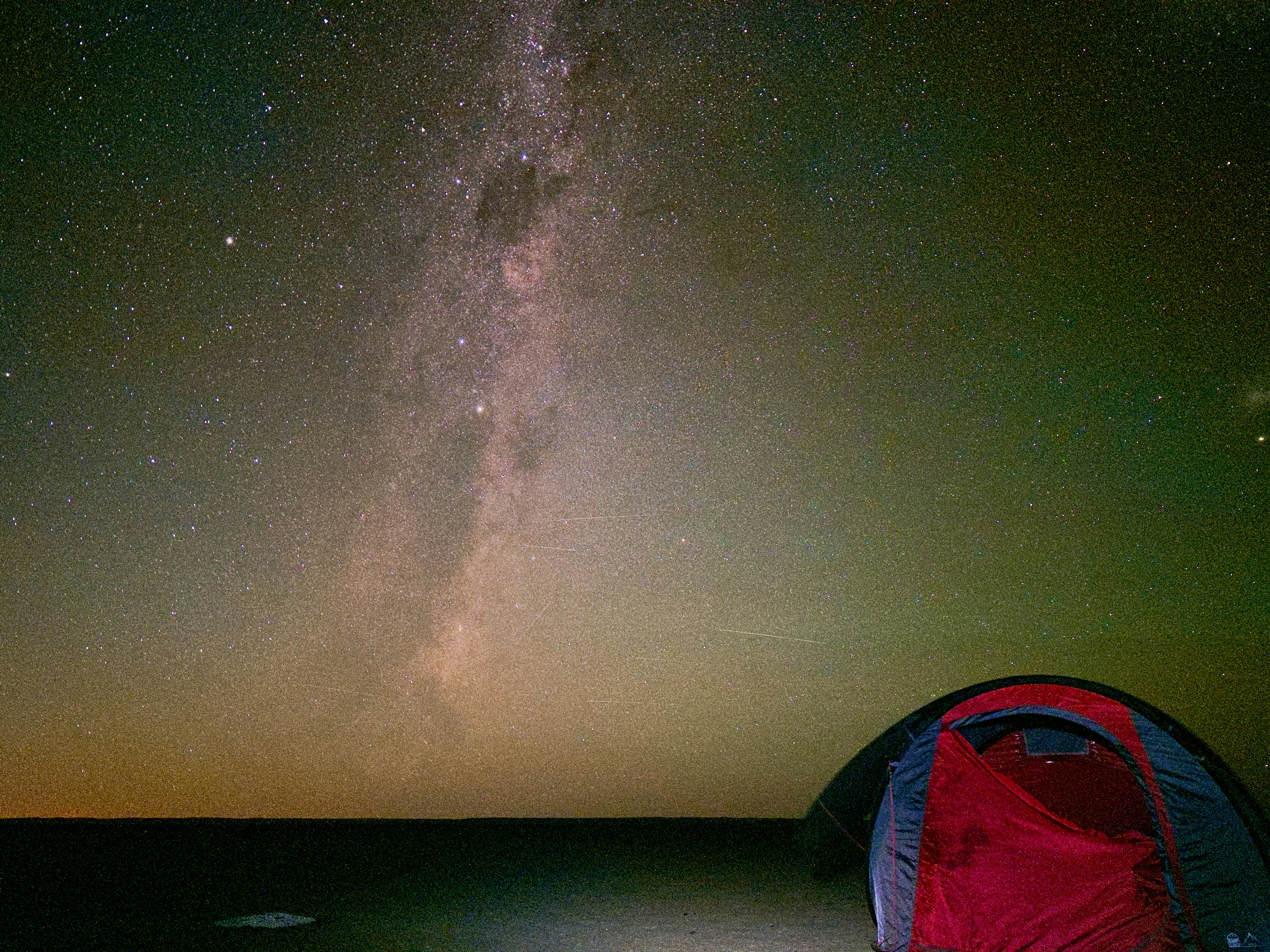 A tent pitched up on a beach under a night sky filled with stars photo ...