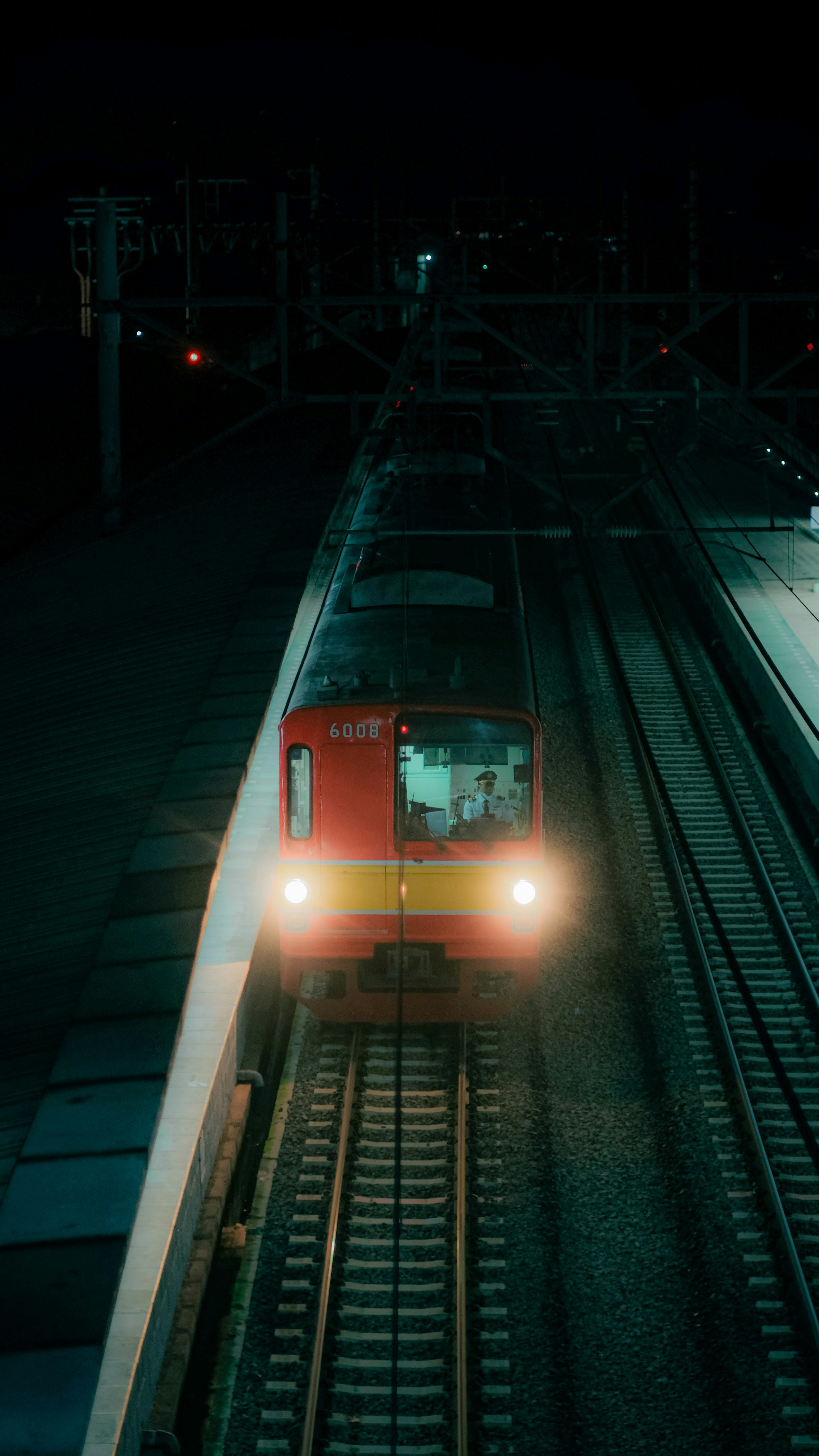 Midnight Approach: A Red Train Surges Toward the Quiet Platform