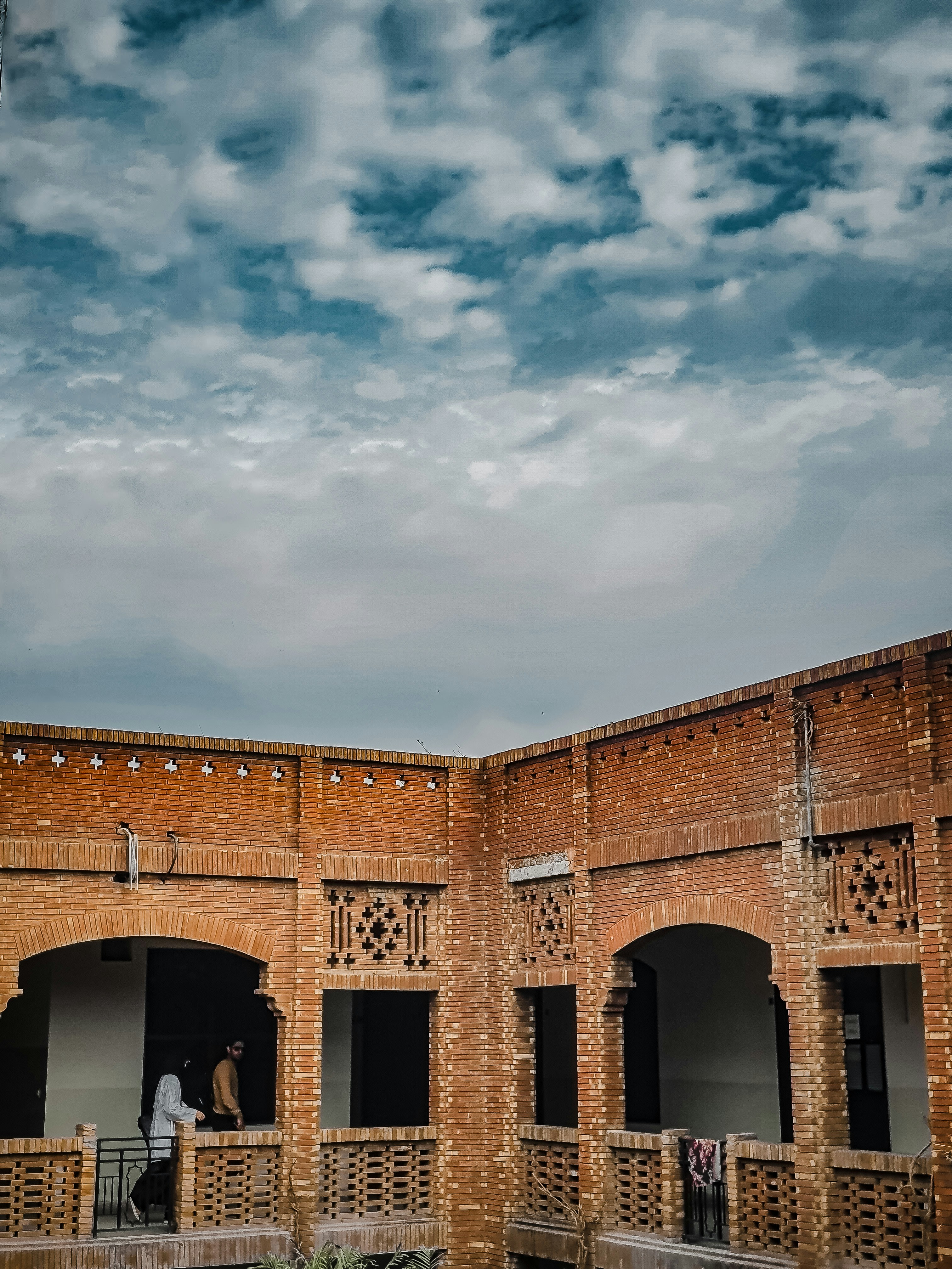 Quiet Duo in a Brick Courtyard Beneath a Wide Sky
