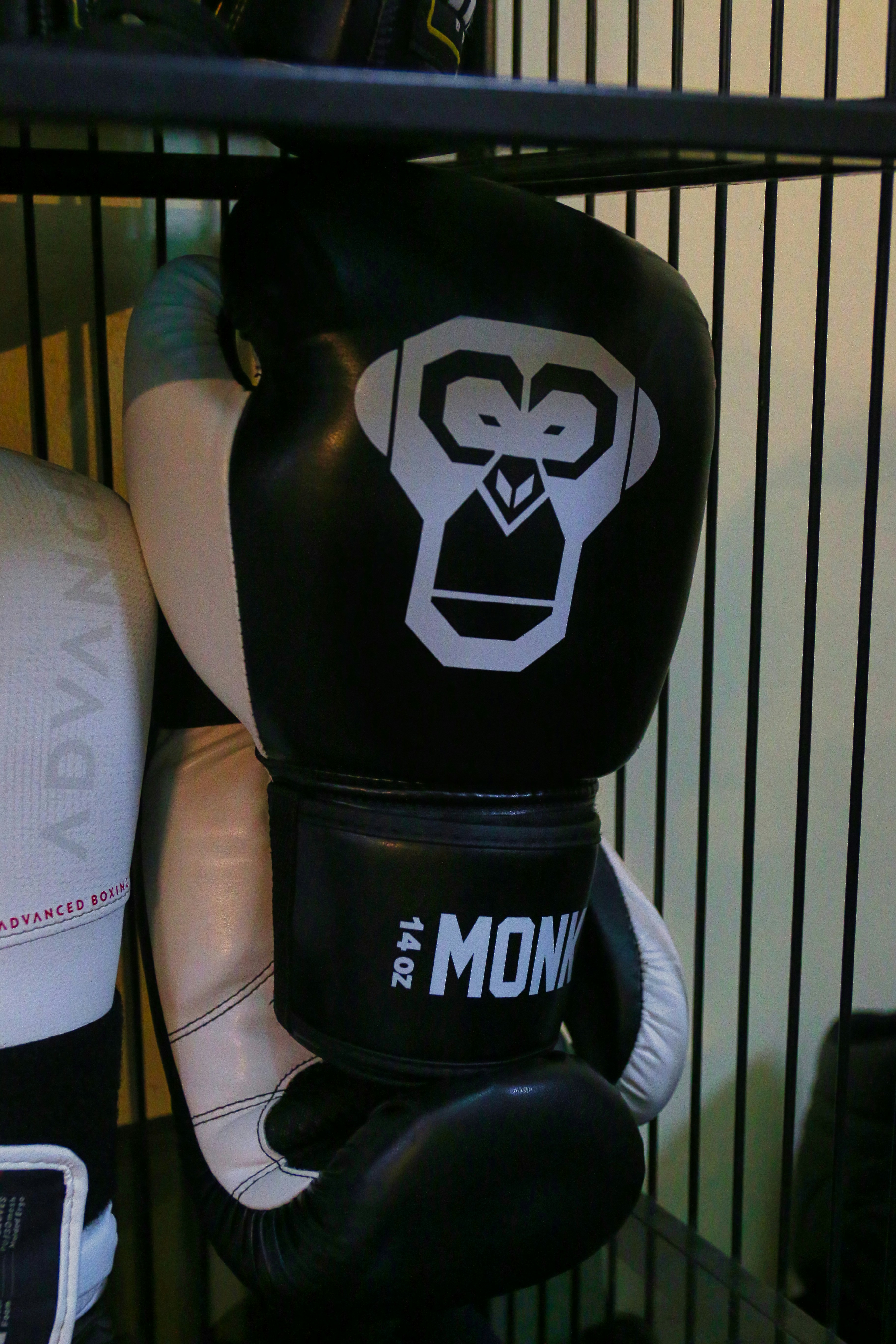 Monochrome Monkey: A Black Boxing Glove with Bold Logo in a Gym Cage